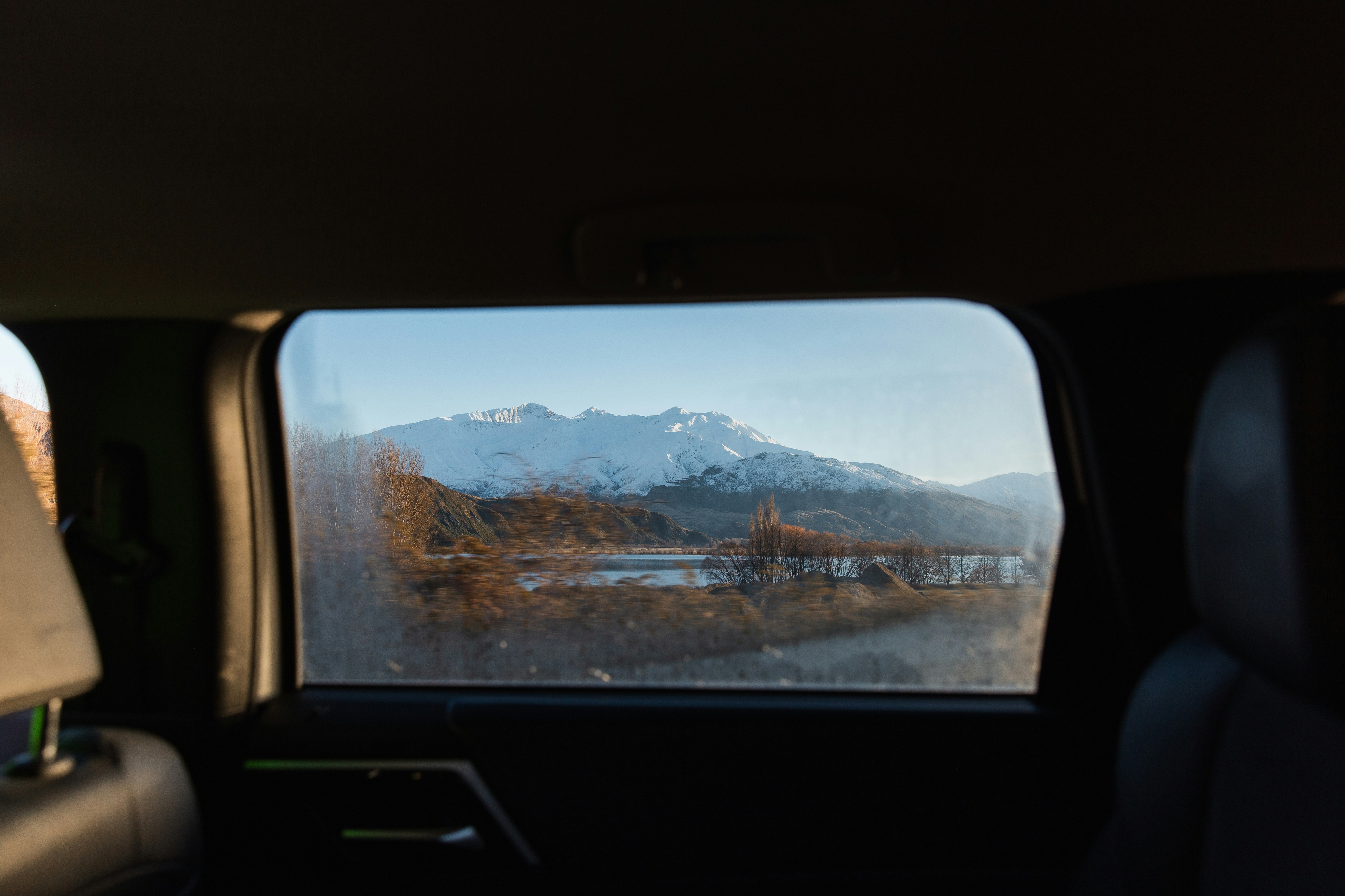 Glimpse of Snow-Crowned Peaks Through a Dim Car Window