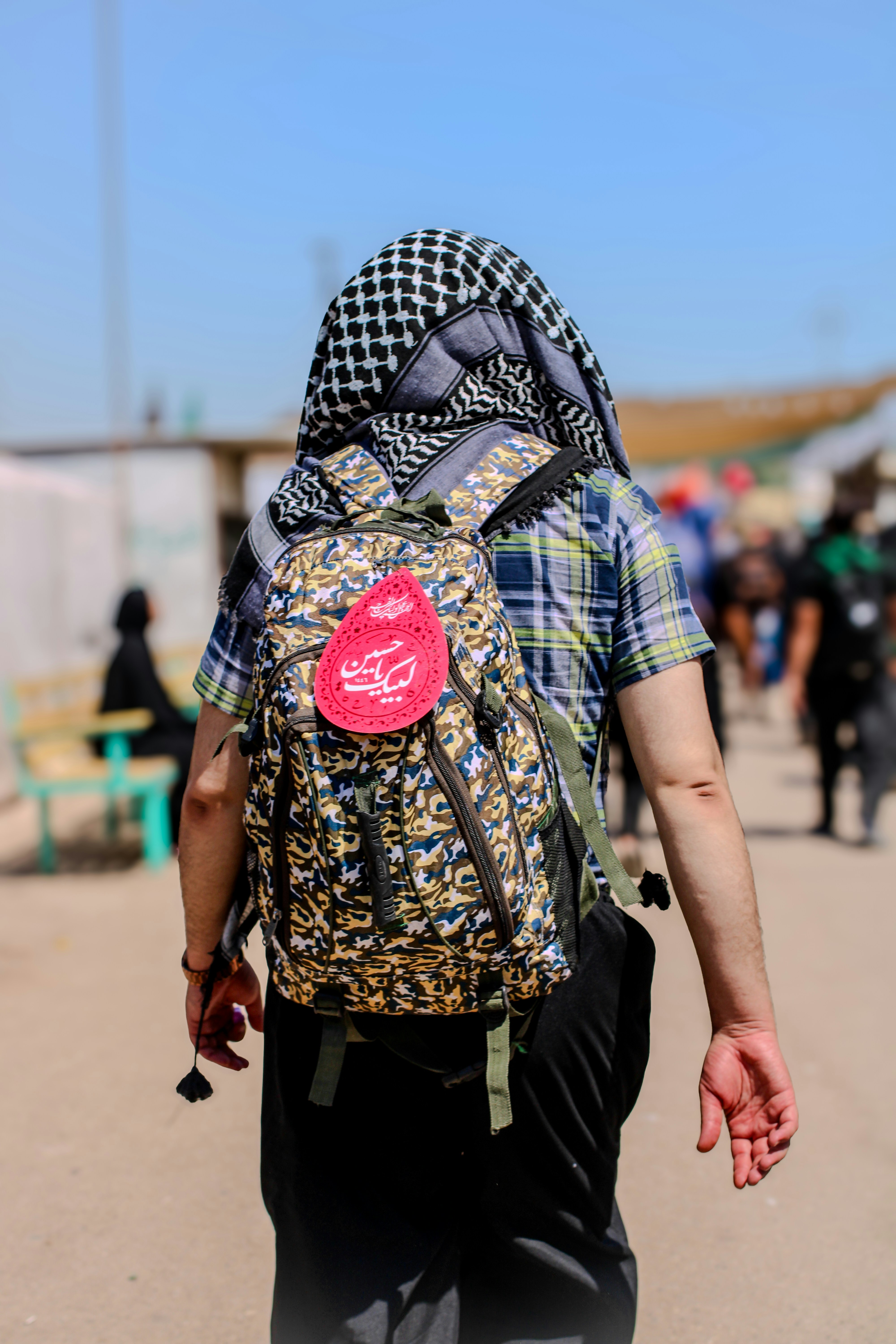 A man with a backpack walking down a street photo – Free Arbaeen Image ...