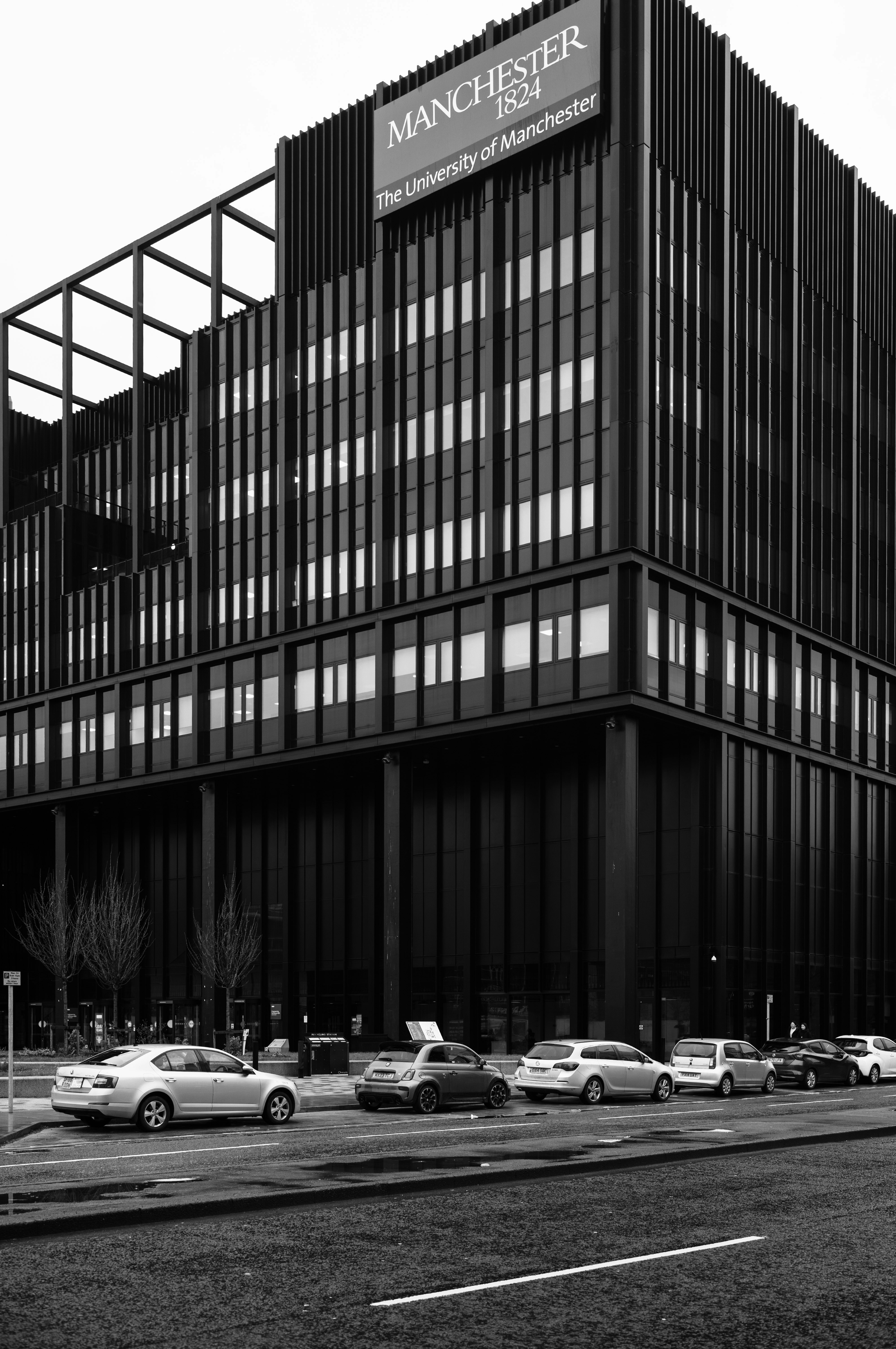 Ribbed Skyward: Manchester Campus Tower Rising Over the Street