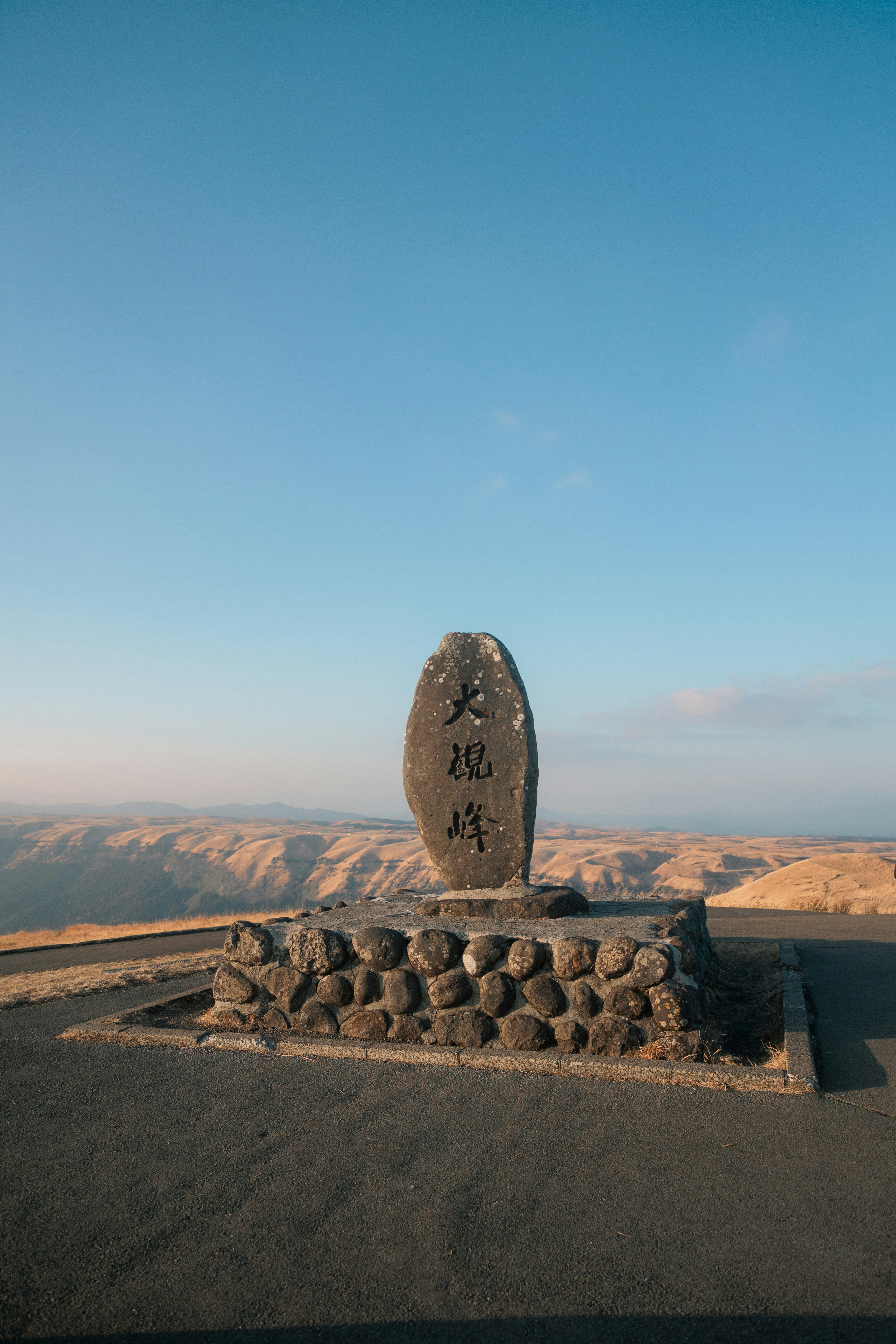 The Summit Stone: A Quiet Monolith Framing a Vast Horizon at Sunset
