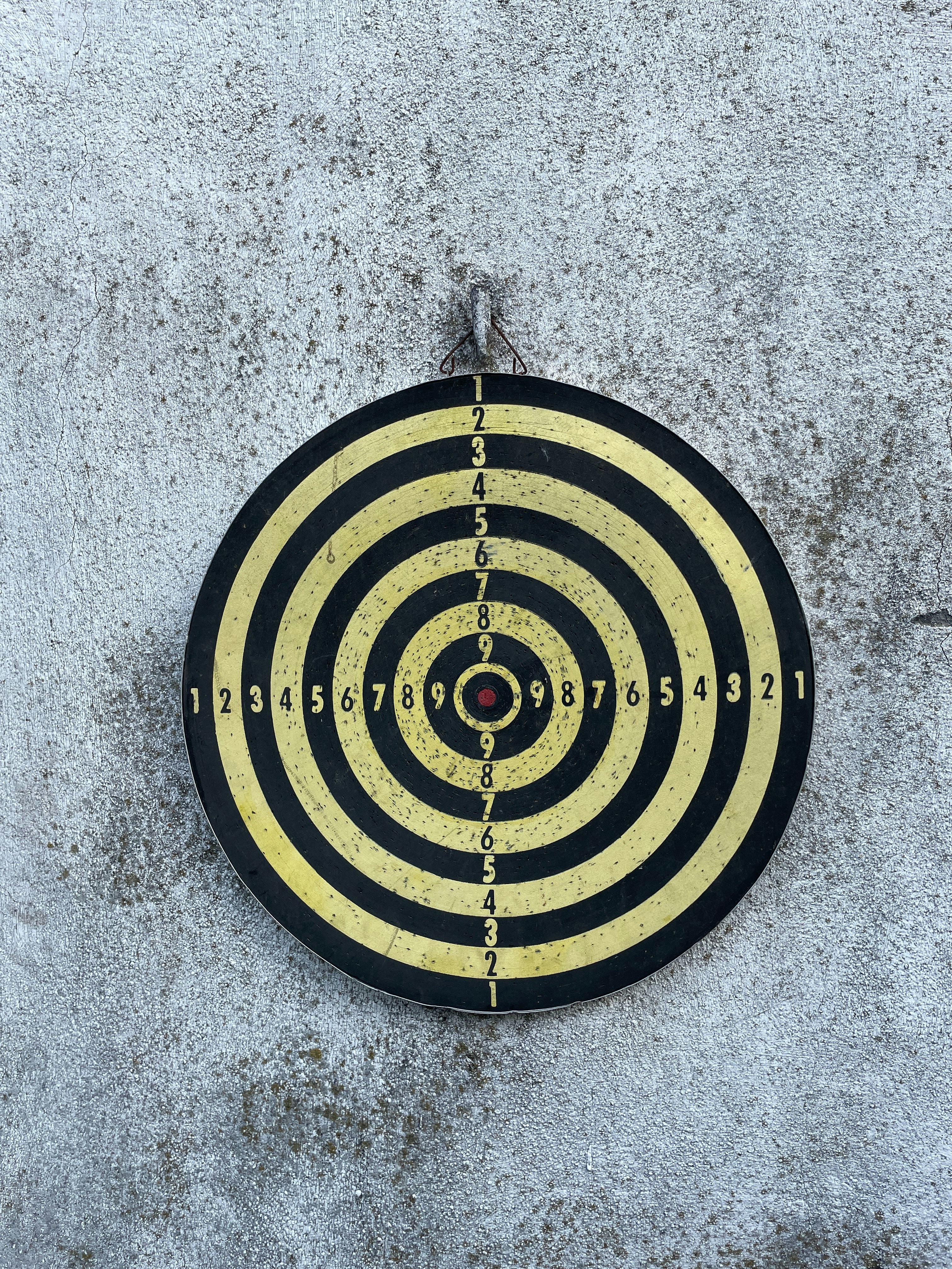 A Dartboard hanging on an old wall