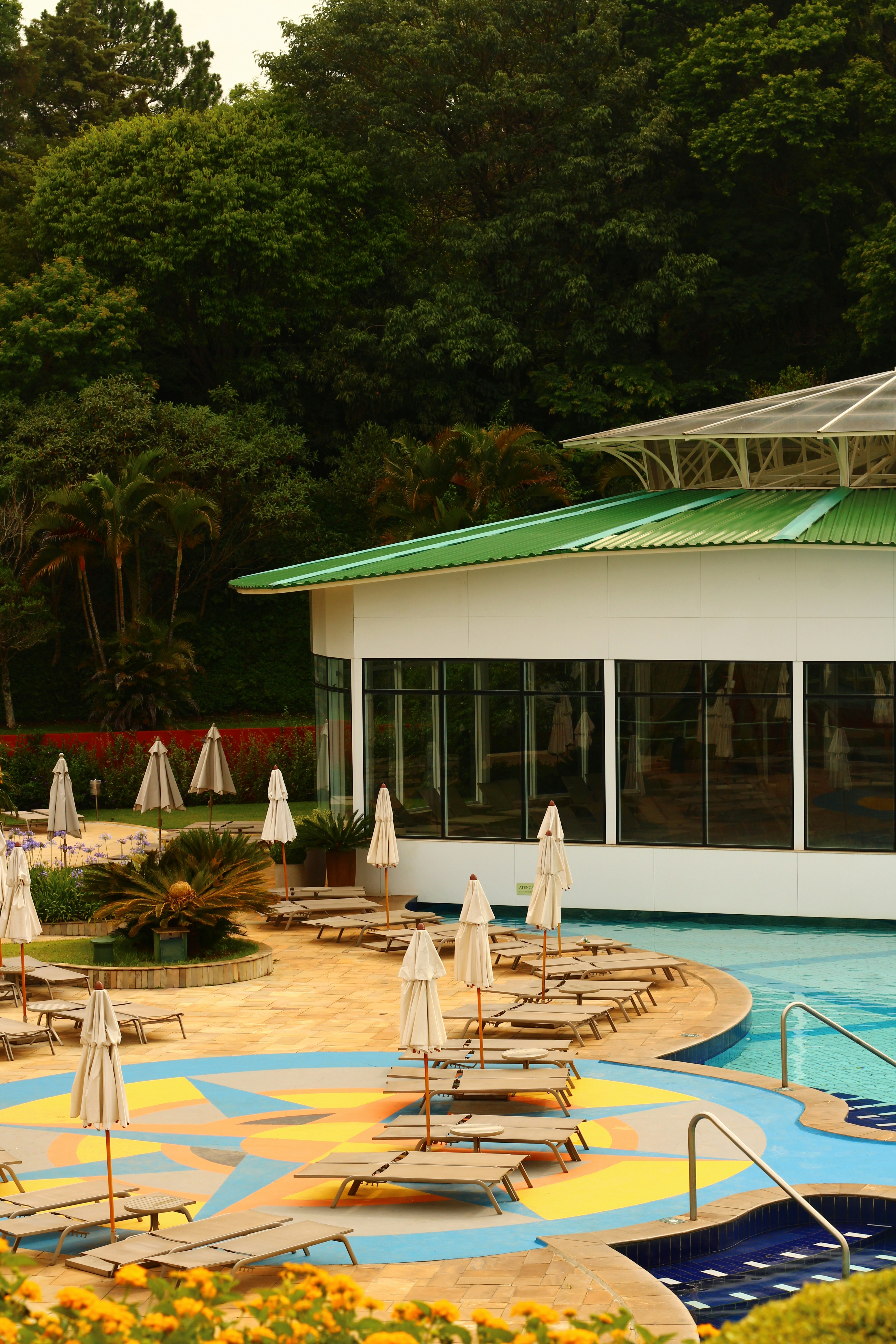Colorful Poolside Mosaic Under a Glass Pavilion