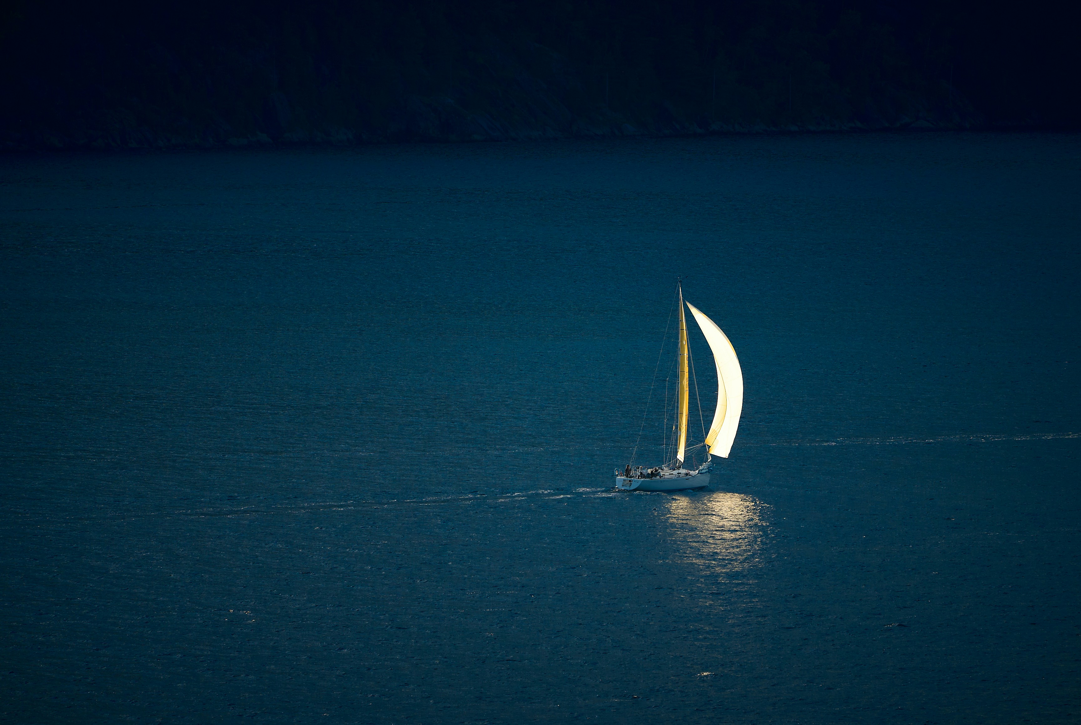 A sailboat in the middle of the ocean at night photo – Free ...