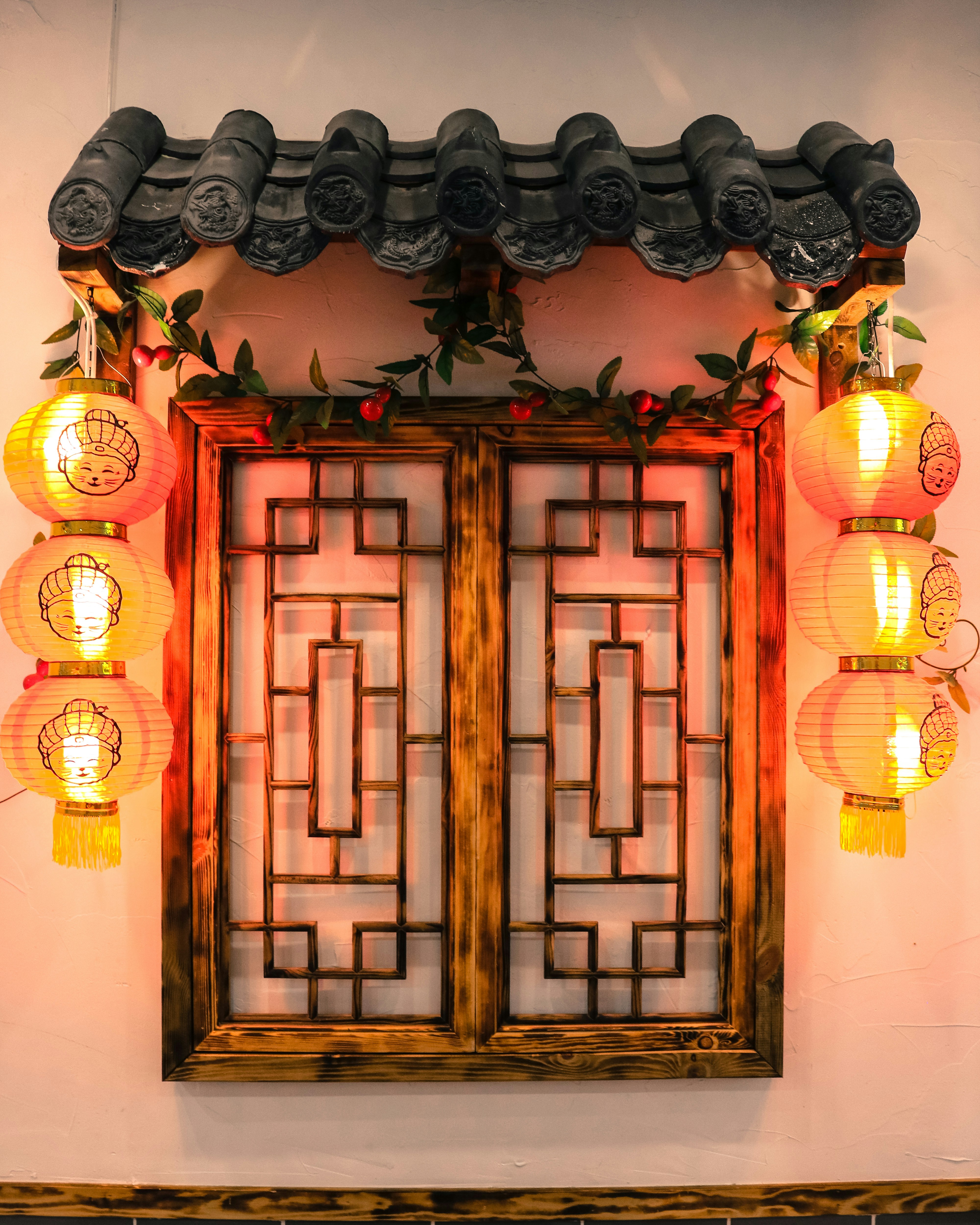 Amber Lanterns Framing a Geometric Window Beneath a Tiled Roof