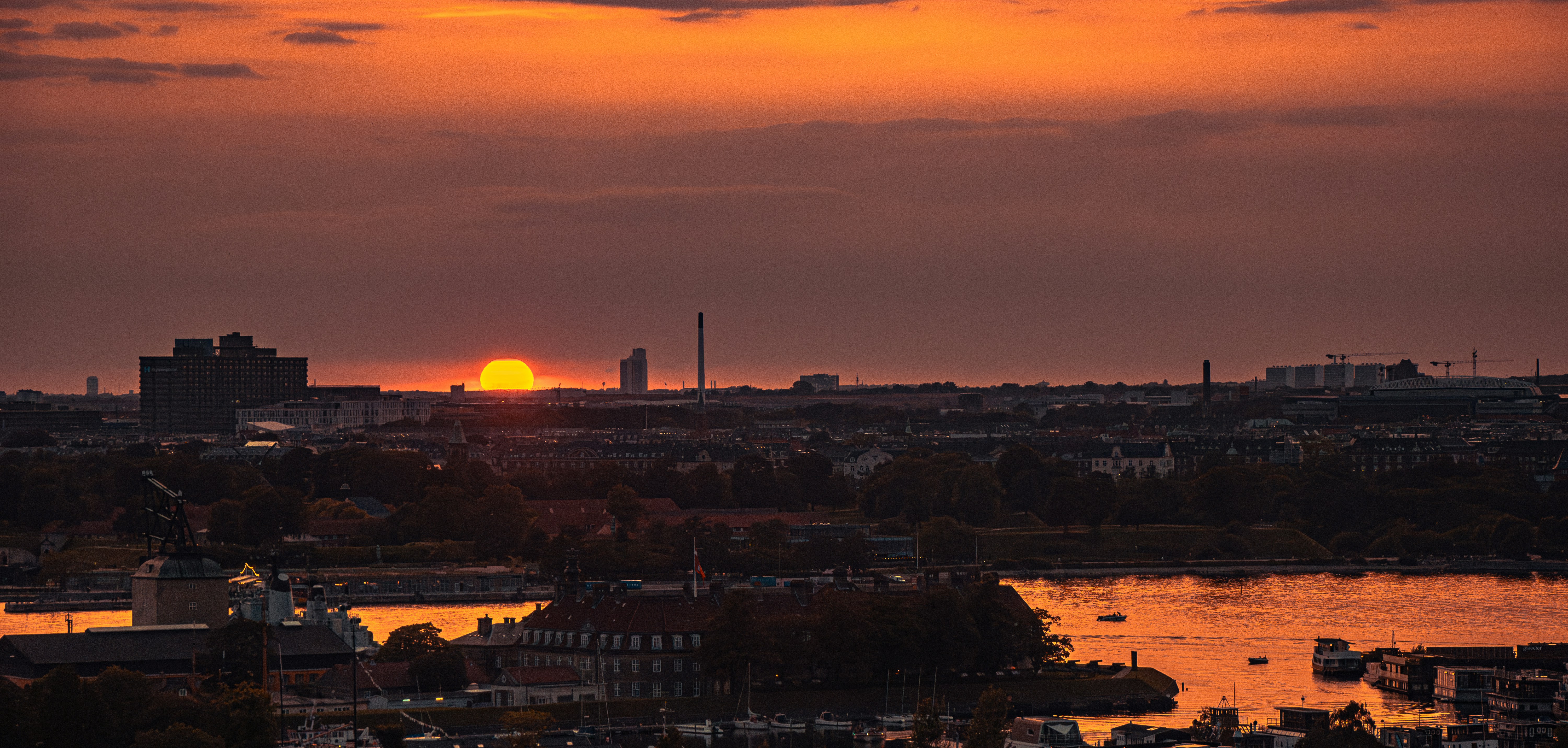 Ember Horizon Over a Quiet Harbor: Sunset Drapes the Skyline in Warm Light