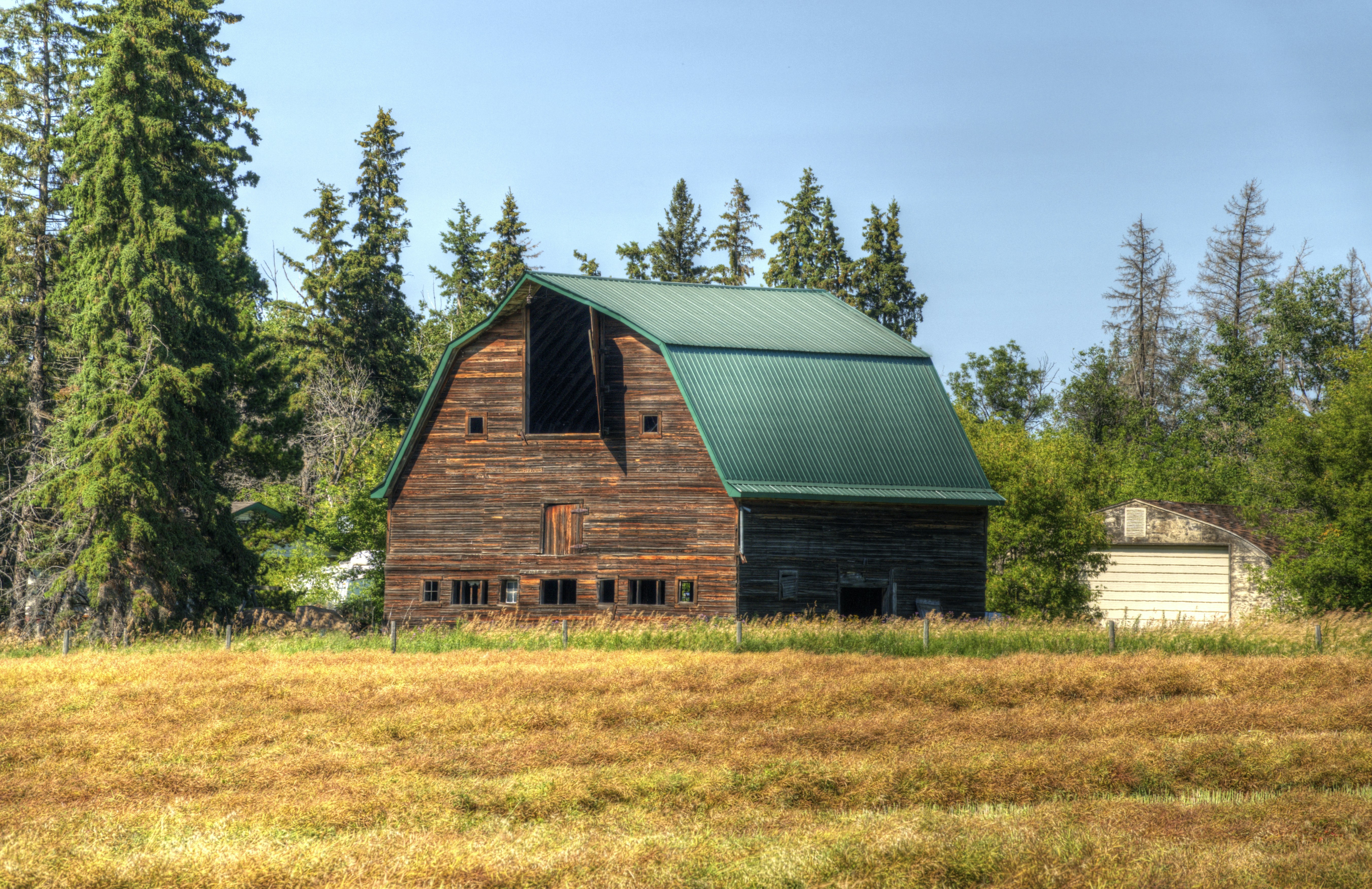 A barn in a field with trees in the background photo – Free Josephburg ...