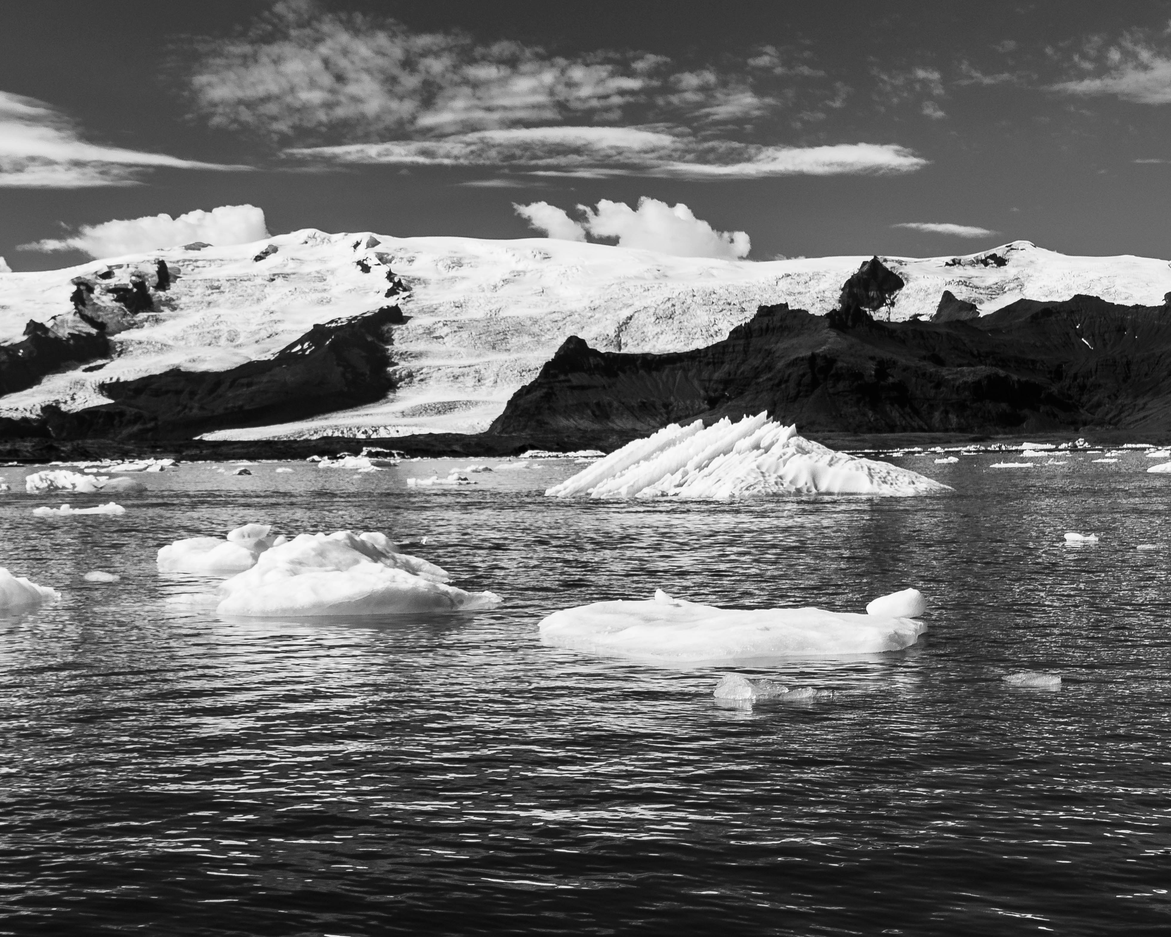 Une photo en noir et blanc d’icebergs flottant dans l’eau photo – Image ...
