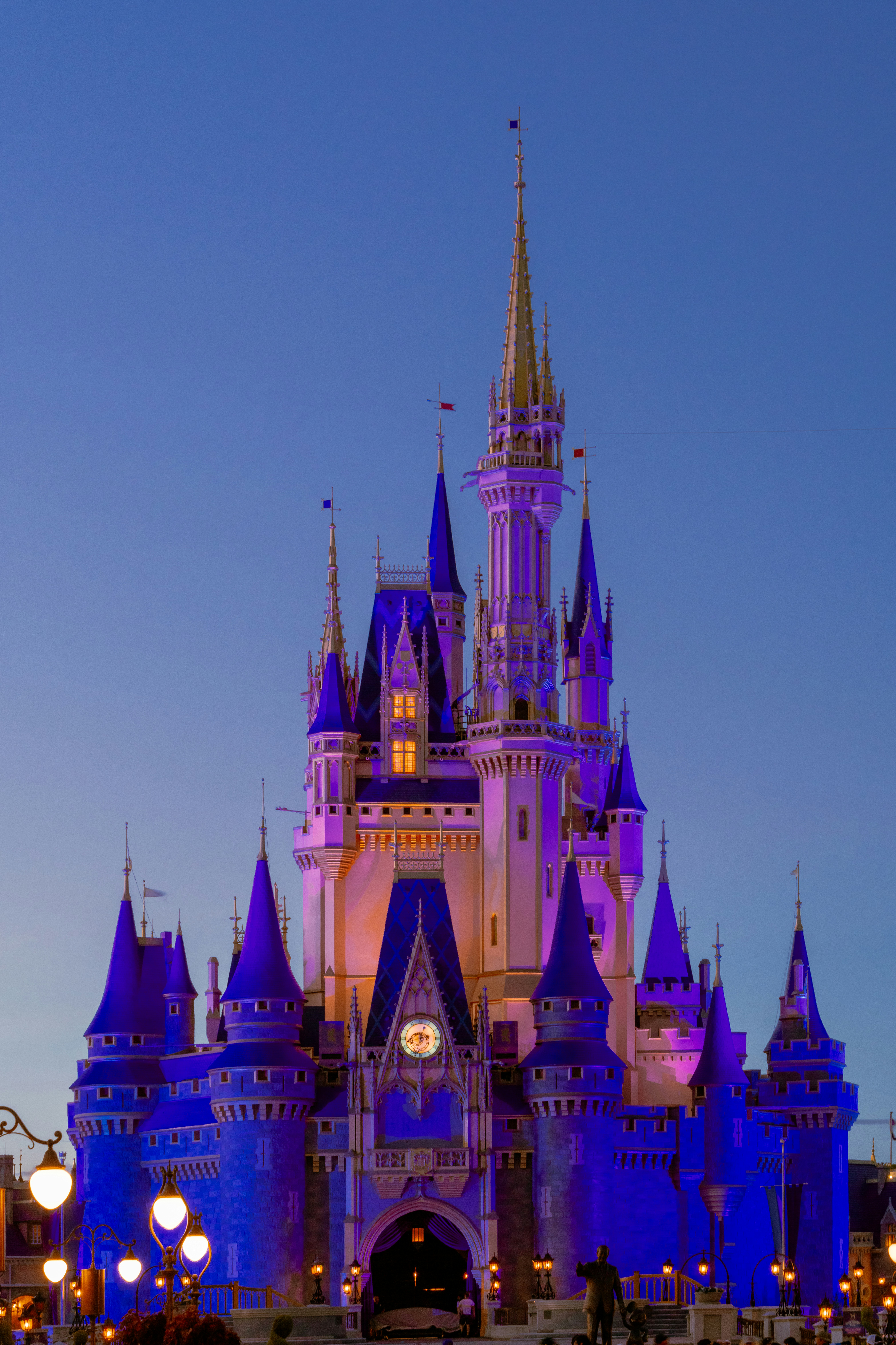 A castle lit up at night with people walking around photo – Free Bay ...