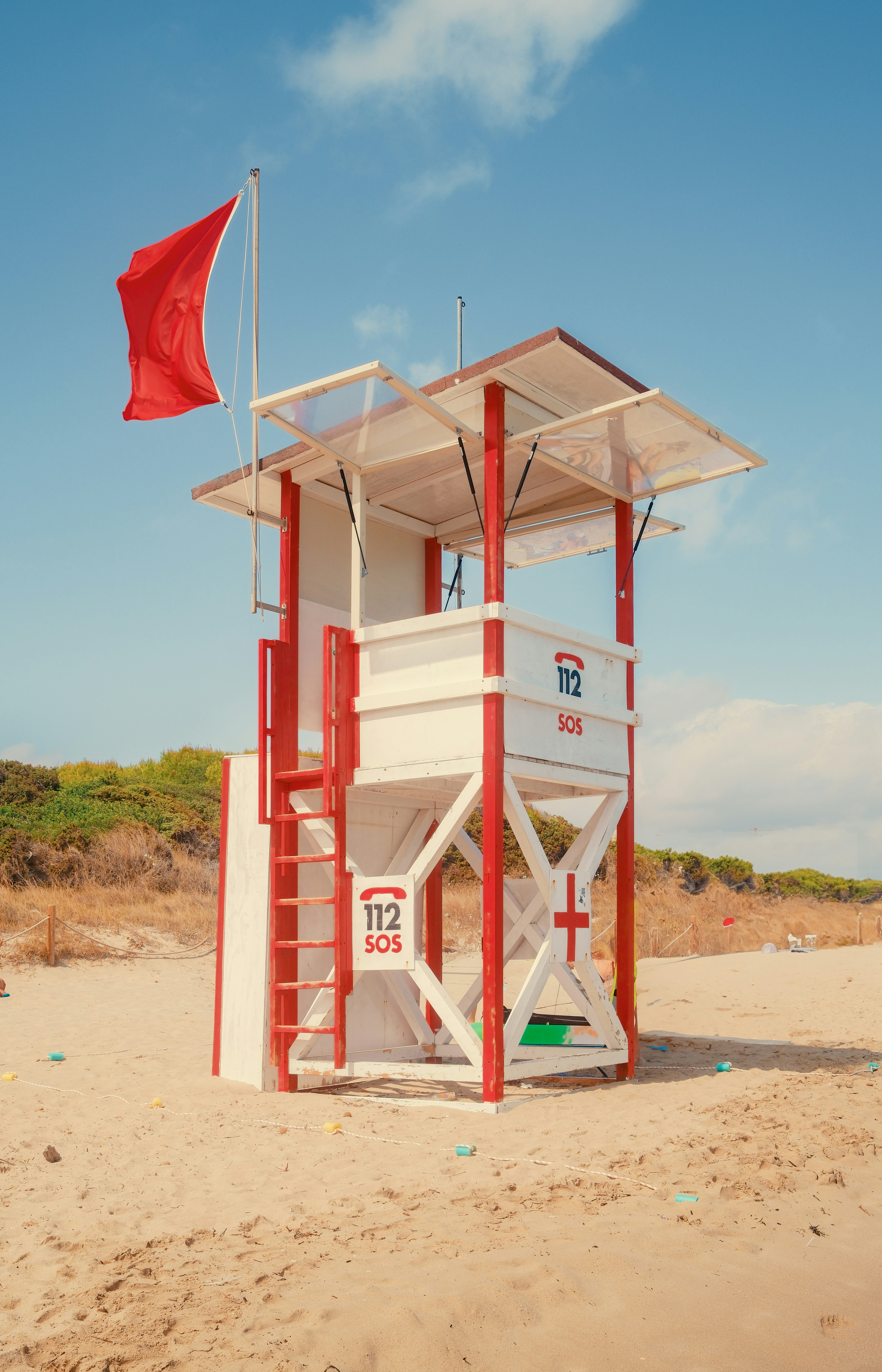Red-White Lifeguard Tower on a Quiet, Sunlit Beach