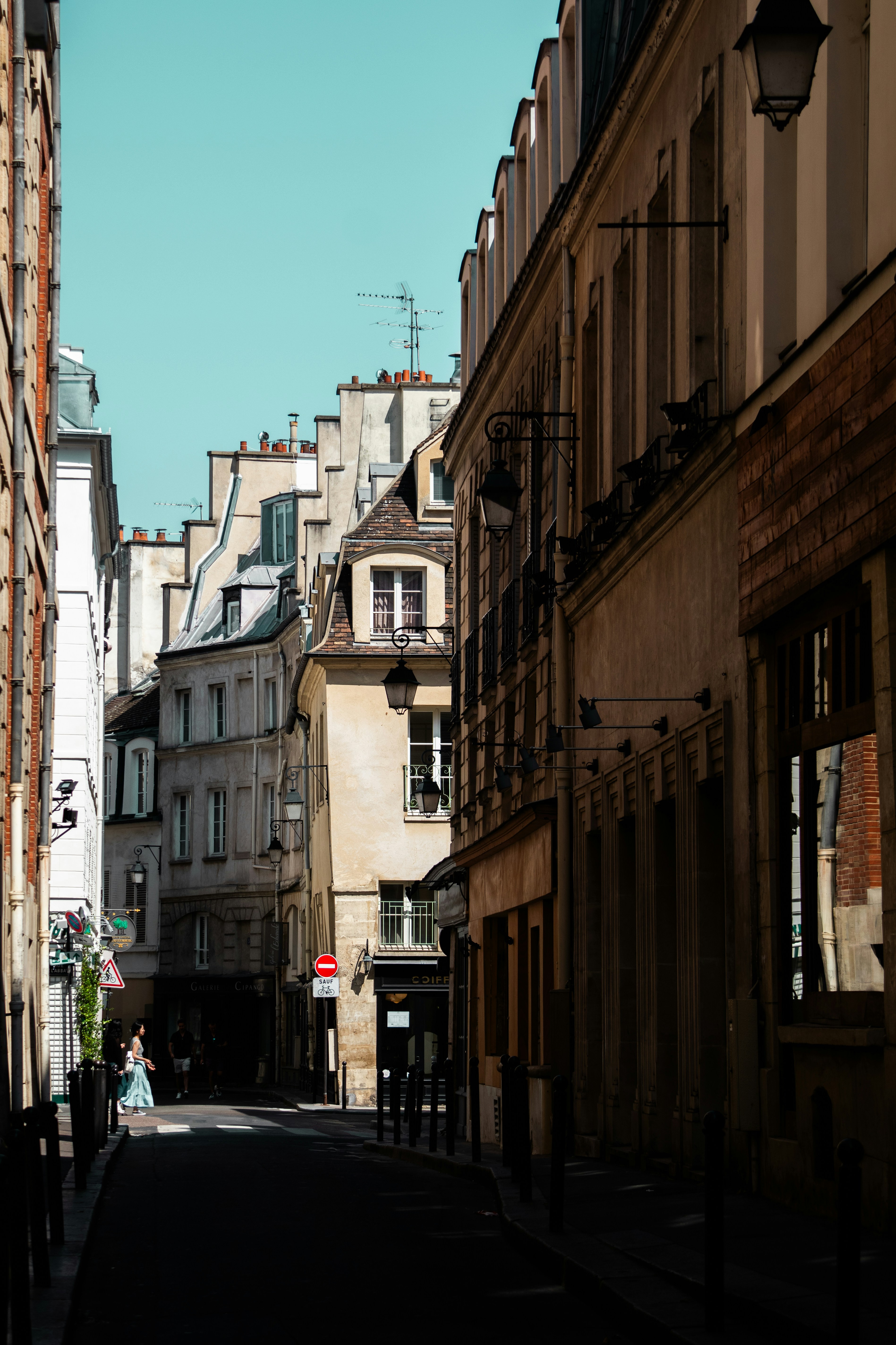 A narrow city street lined with tall buildings photo – Free Paris Image ...