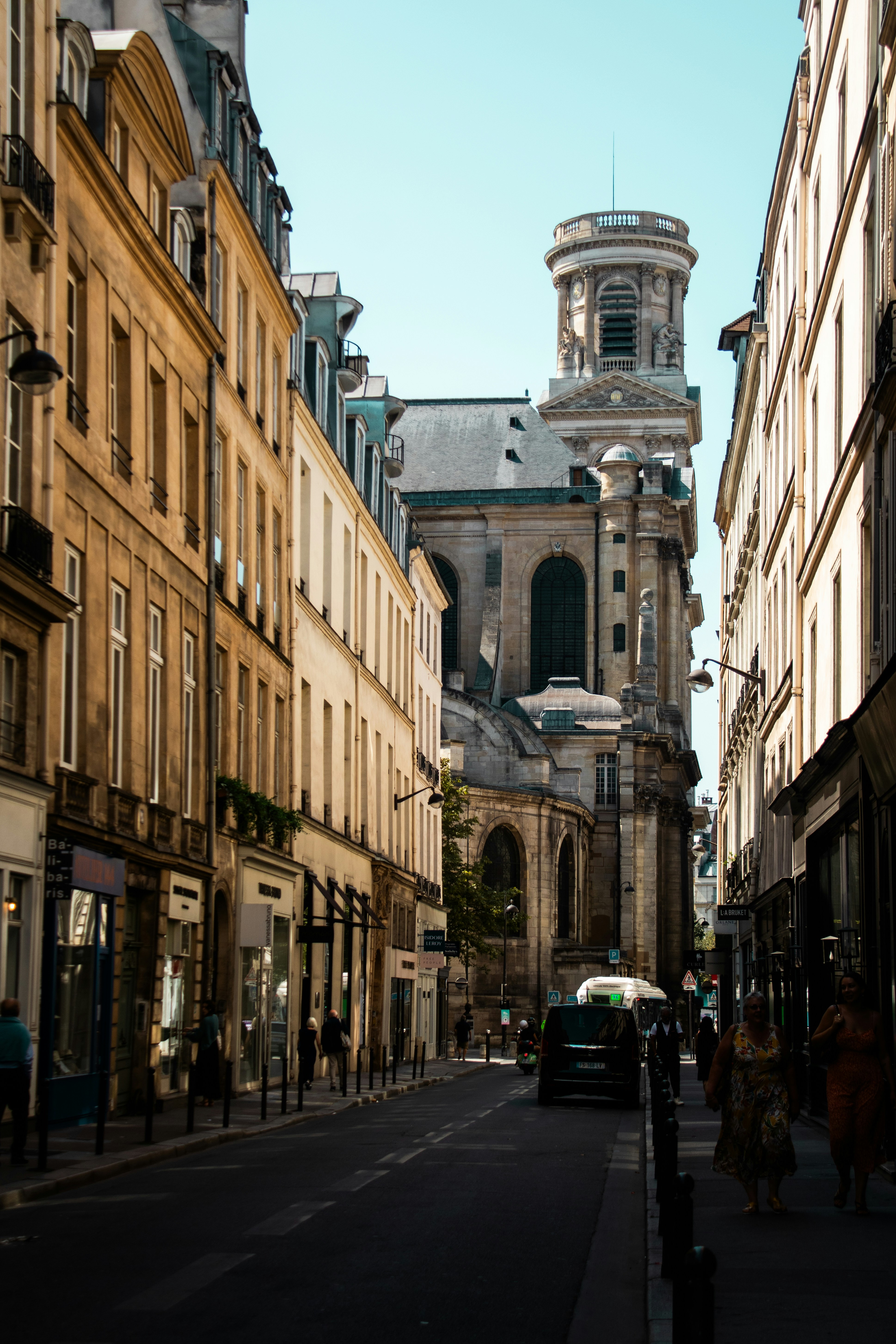 A narrow city street lined with tall buildings photo – Free Woman Image ...