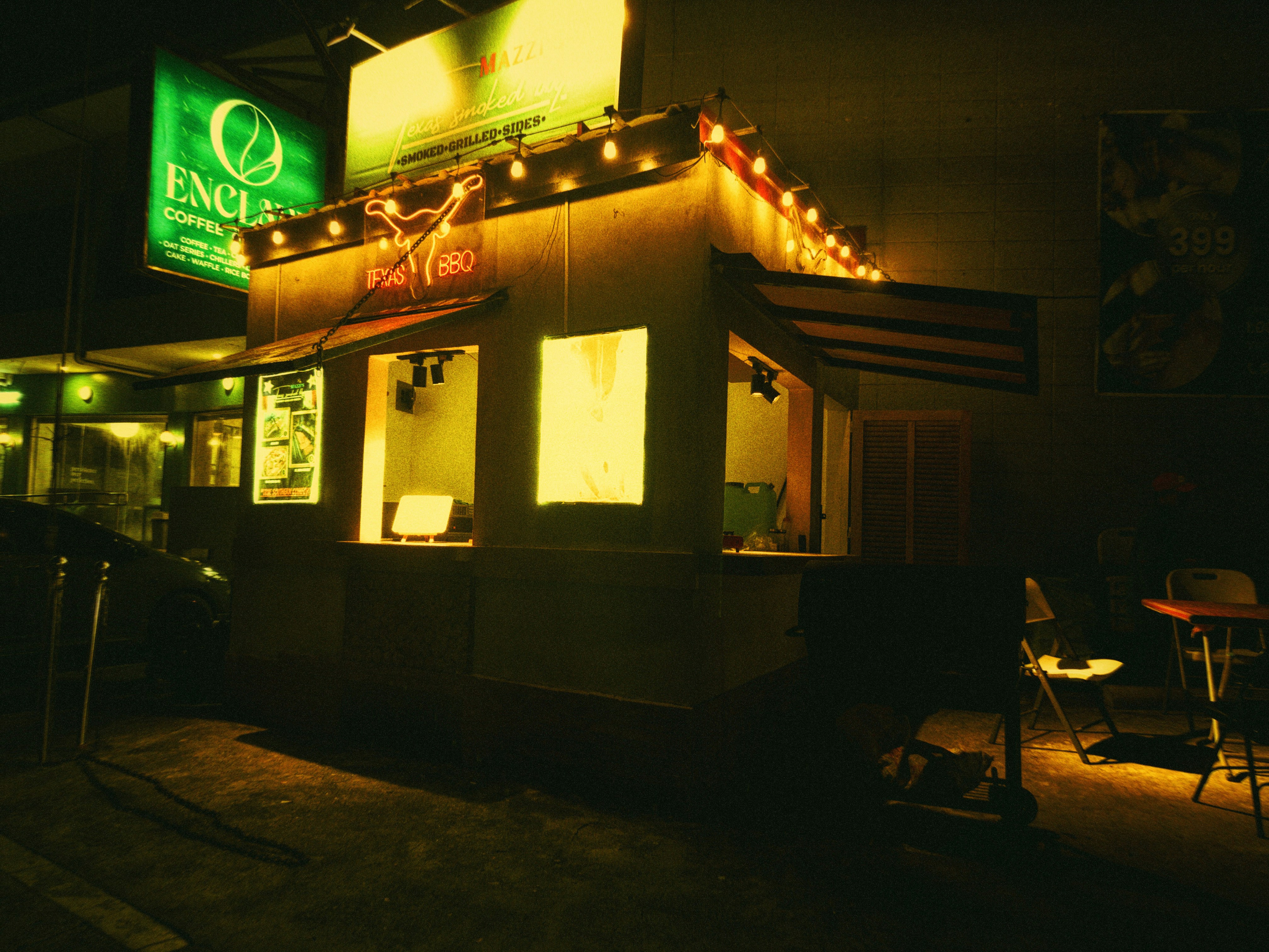 A small restaurant with a lit up sign at night photo – Free Car Image ...