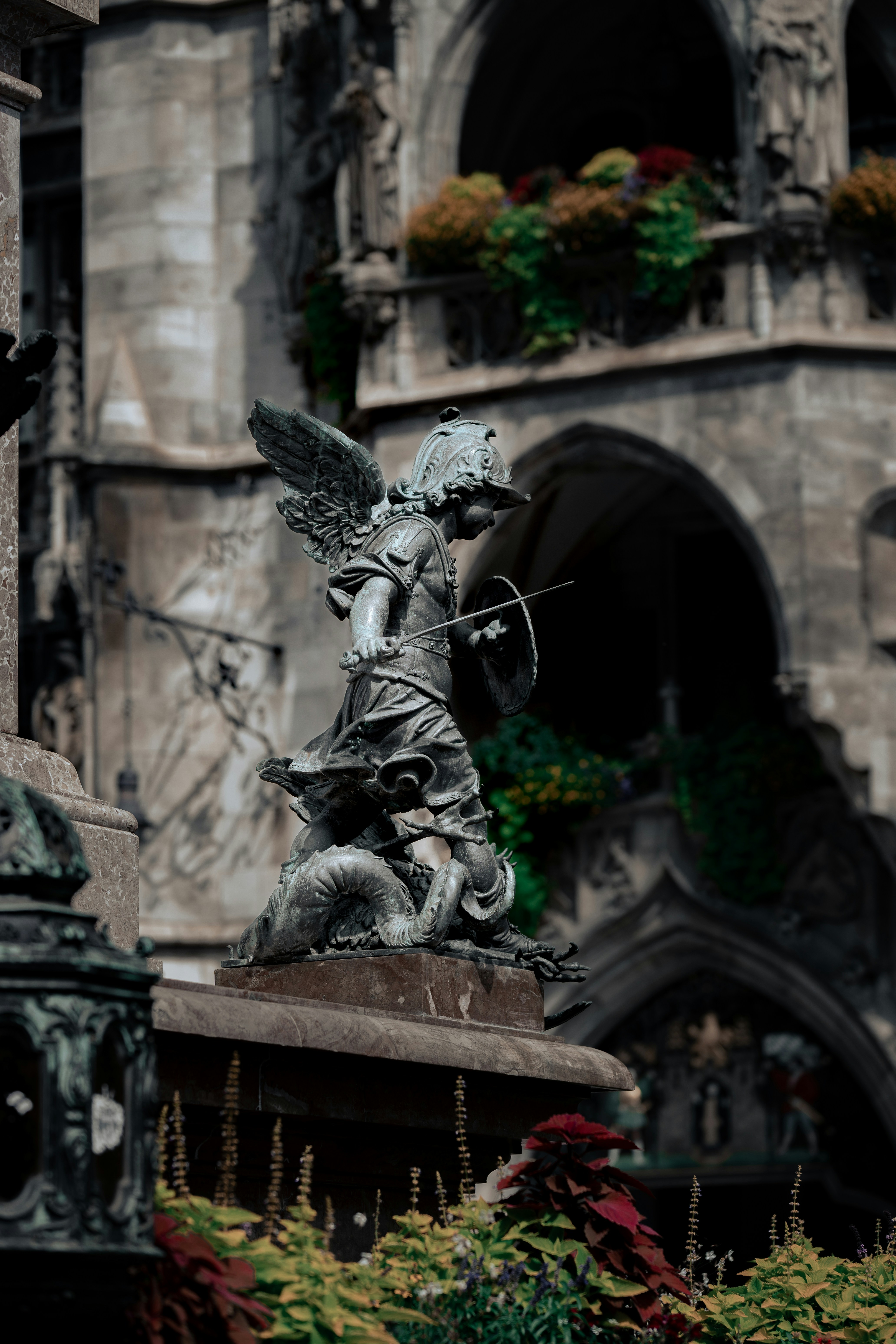 A statue of an angel on a ledge in front of a building photo – Free ...