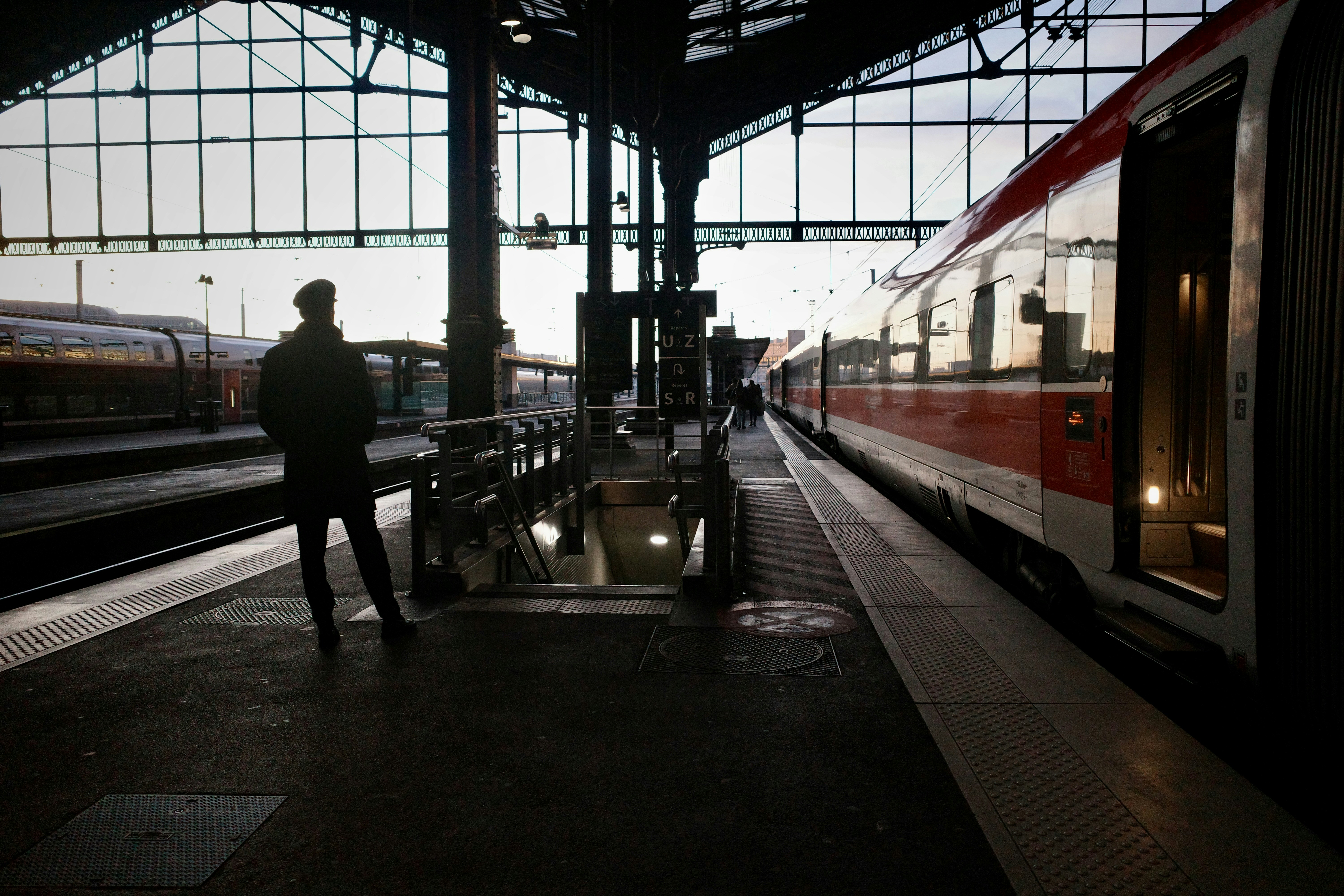 A man standing in a train station next to a train photo – Free Train ...