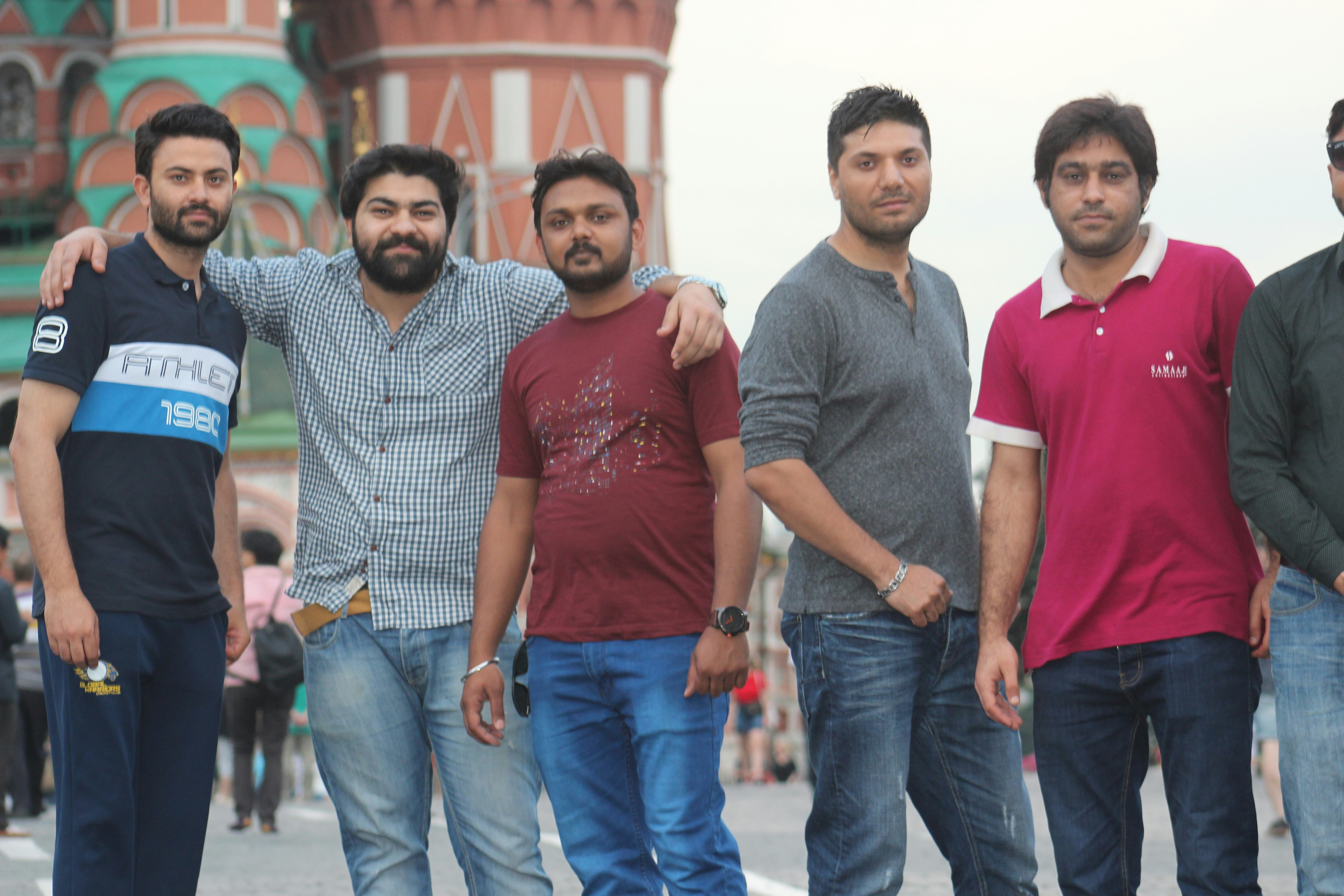Group of friends standing together with vibrant, historic building in the background.