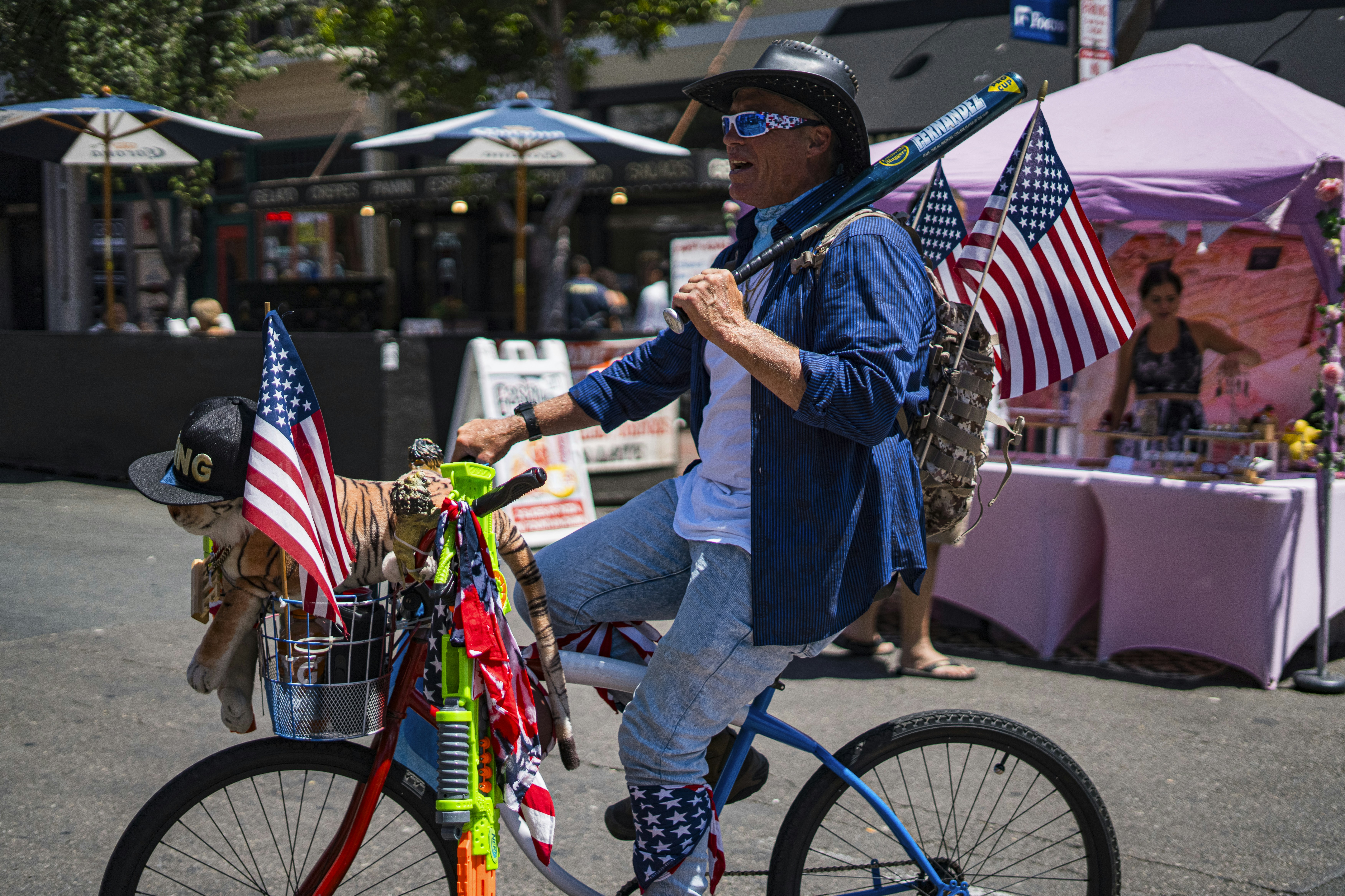 A man riding a bike with an american flag on it photo – Free Gaslamp ...