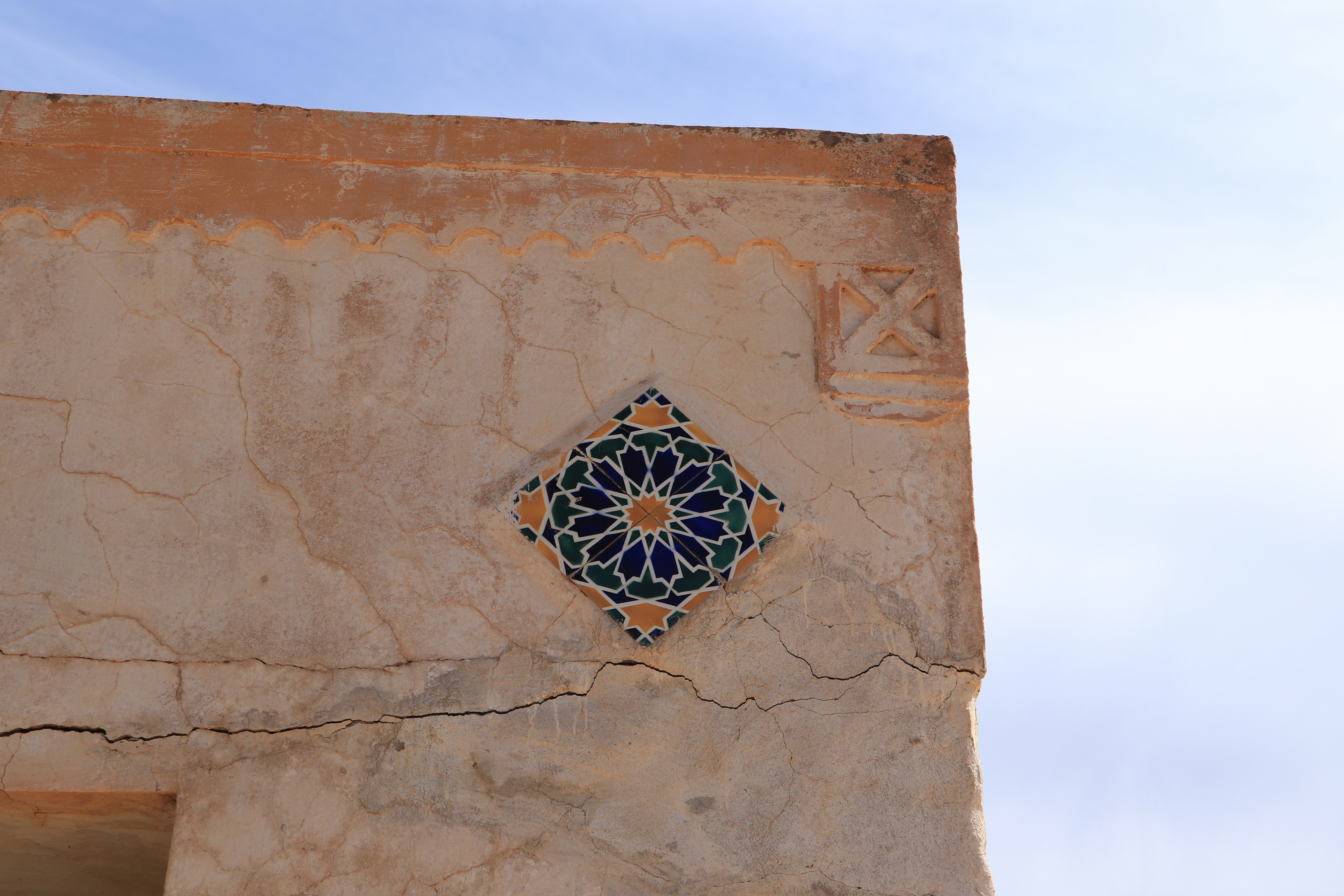 Blue Mandala Diamond on a Weathered Plaster Facade
