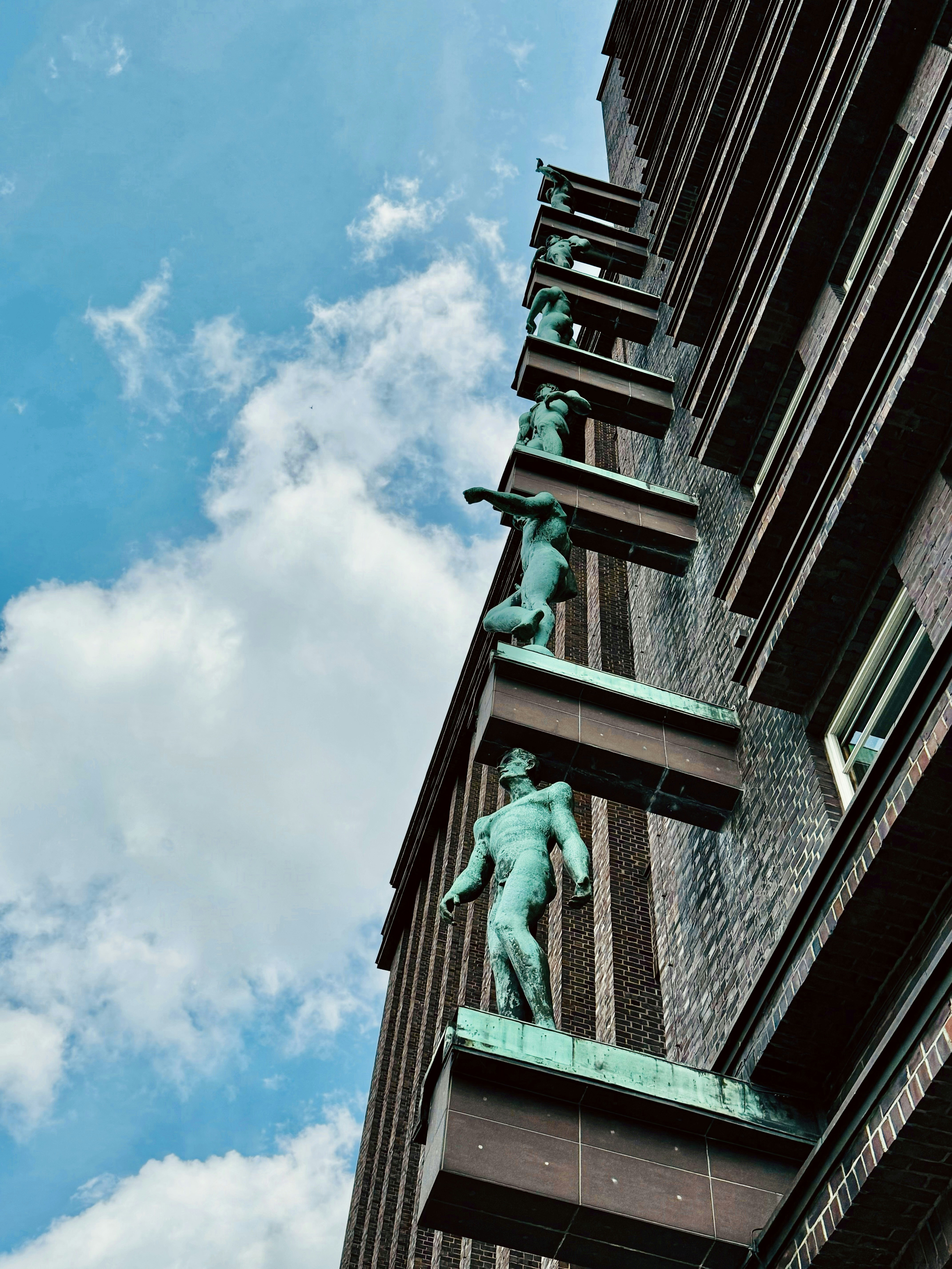 Vertical Verve: Patinated Figures Along a Skyward Facade