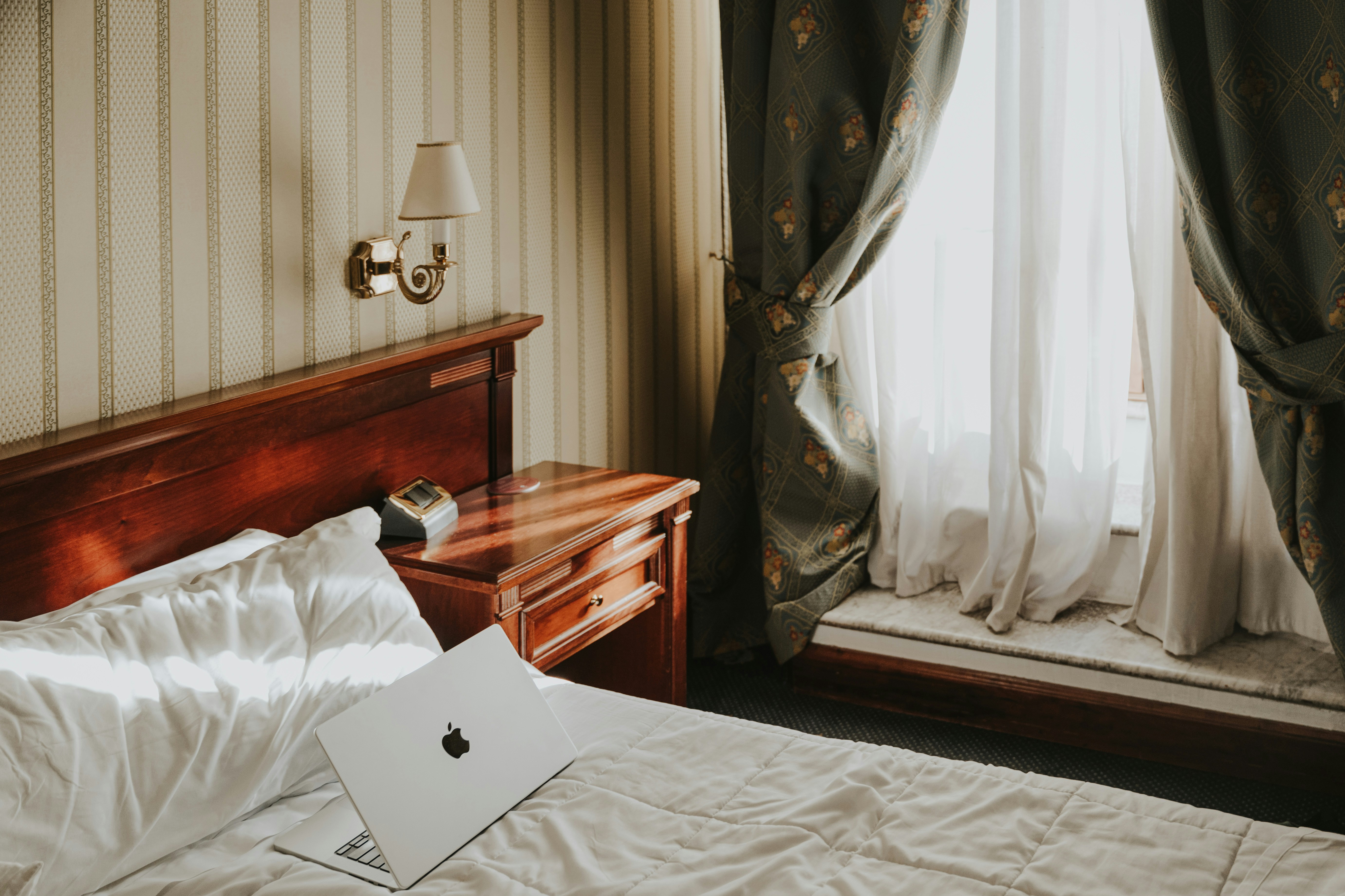 A laptop computer sitting on top of a bed photo – Free Apple Image on ...