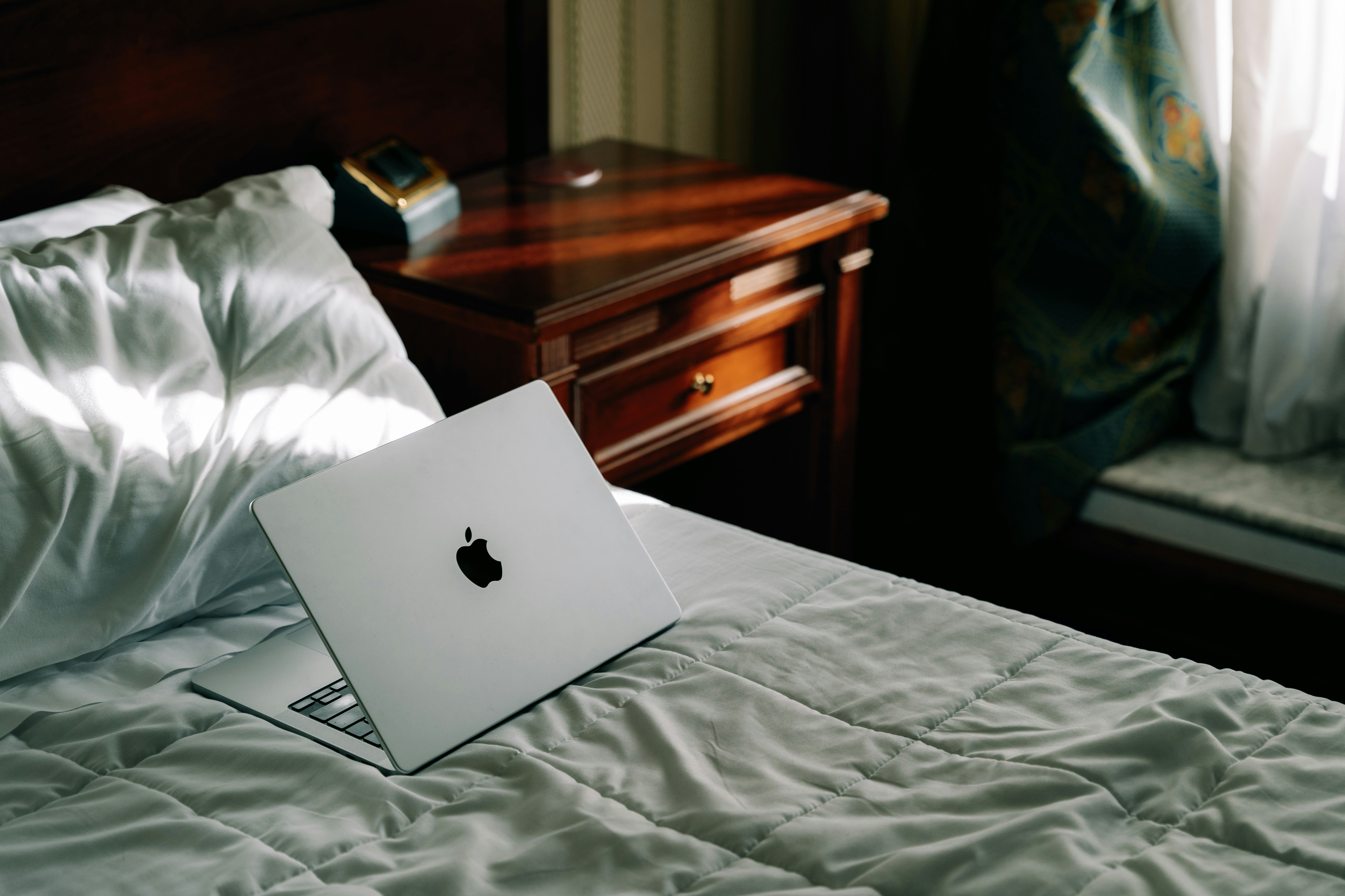 A laptop computer sitting on top of a bed photo – Free Computer Image ...