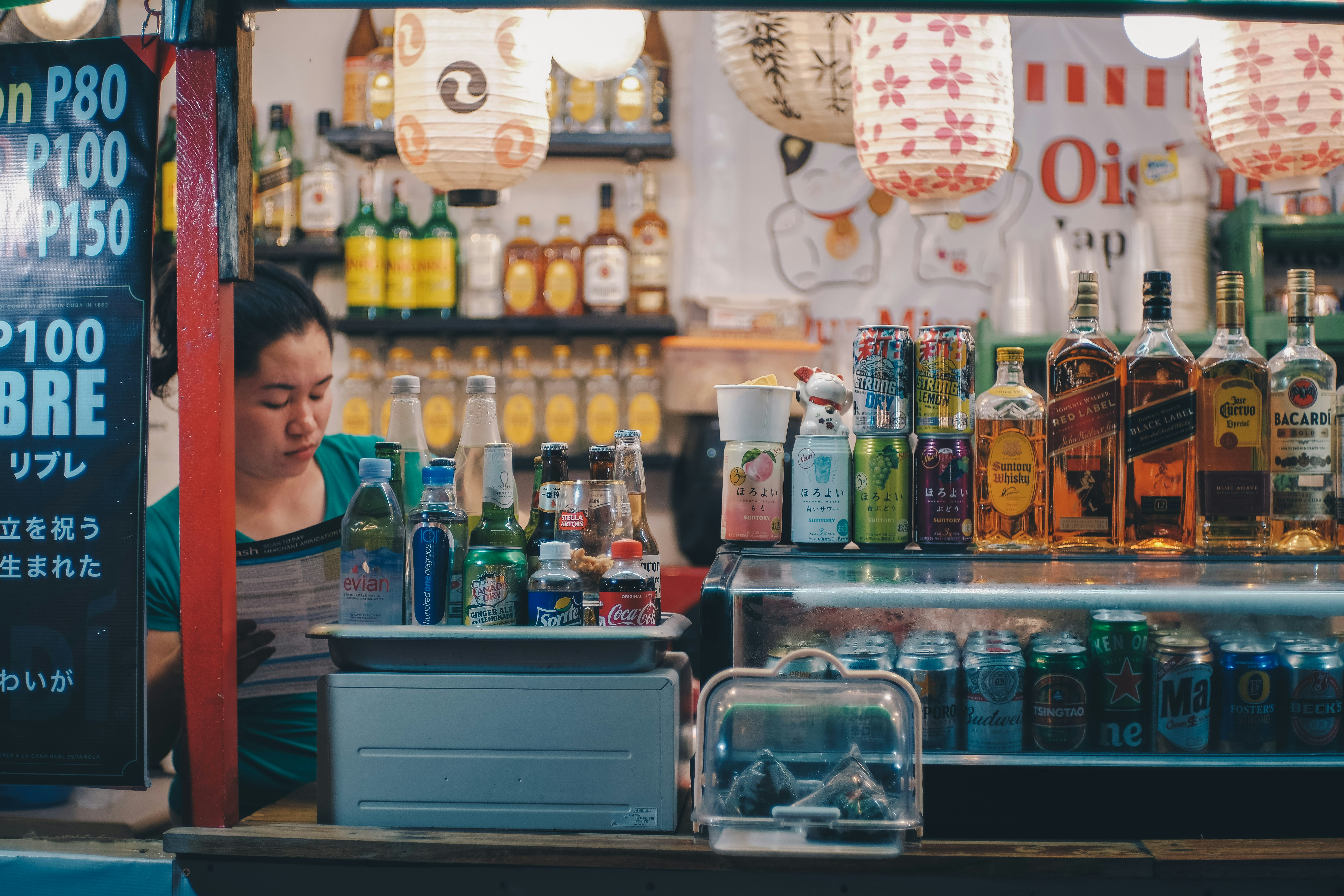 A man behind a bar with bottles of alcohol behind him photo – Free Cebu ...