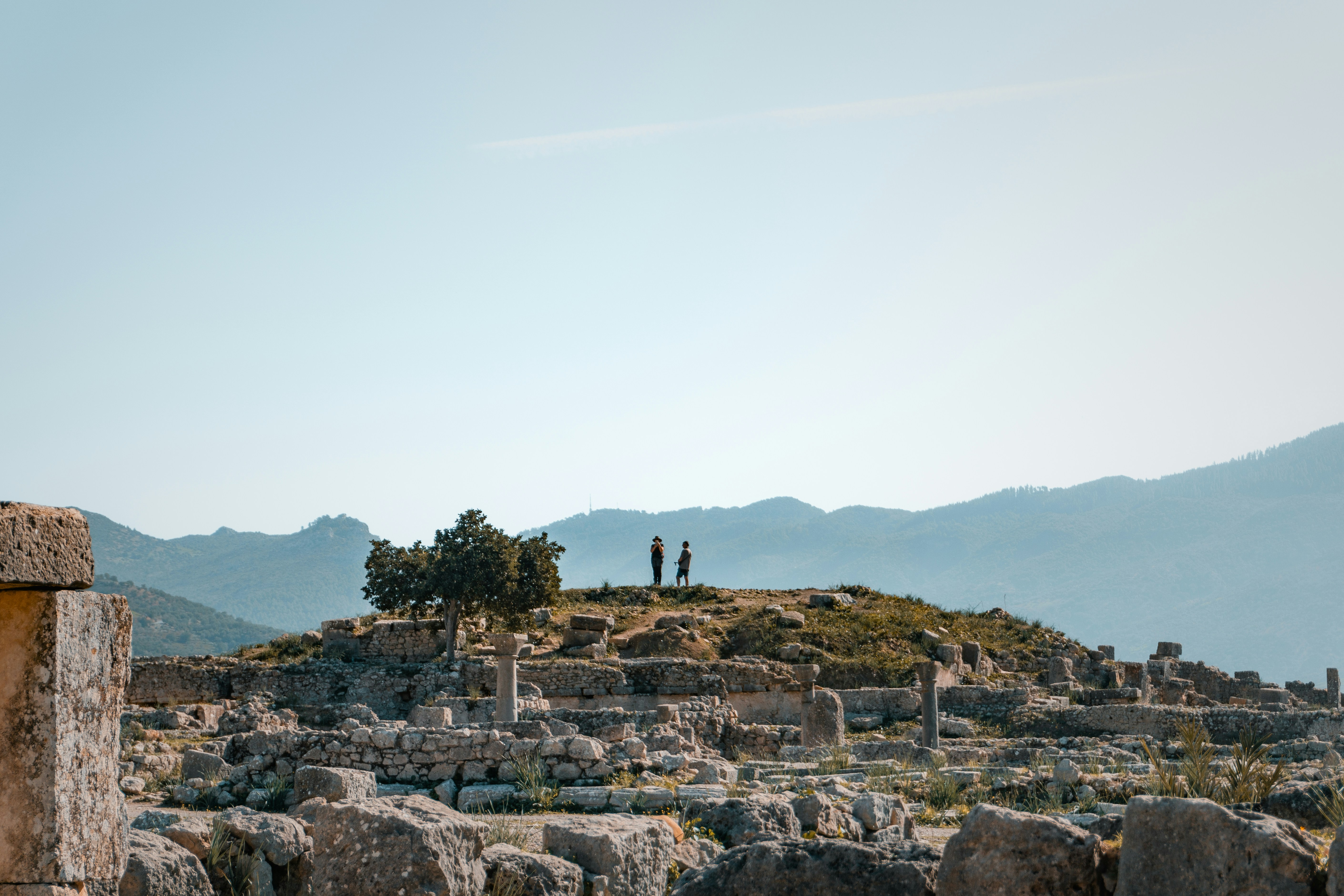 A statue of a man standing on top of a hill photo – Free Oualili Image ...