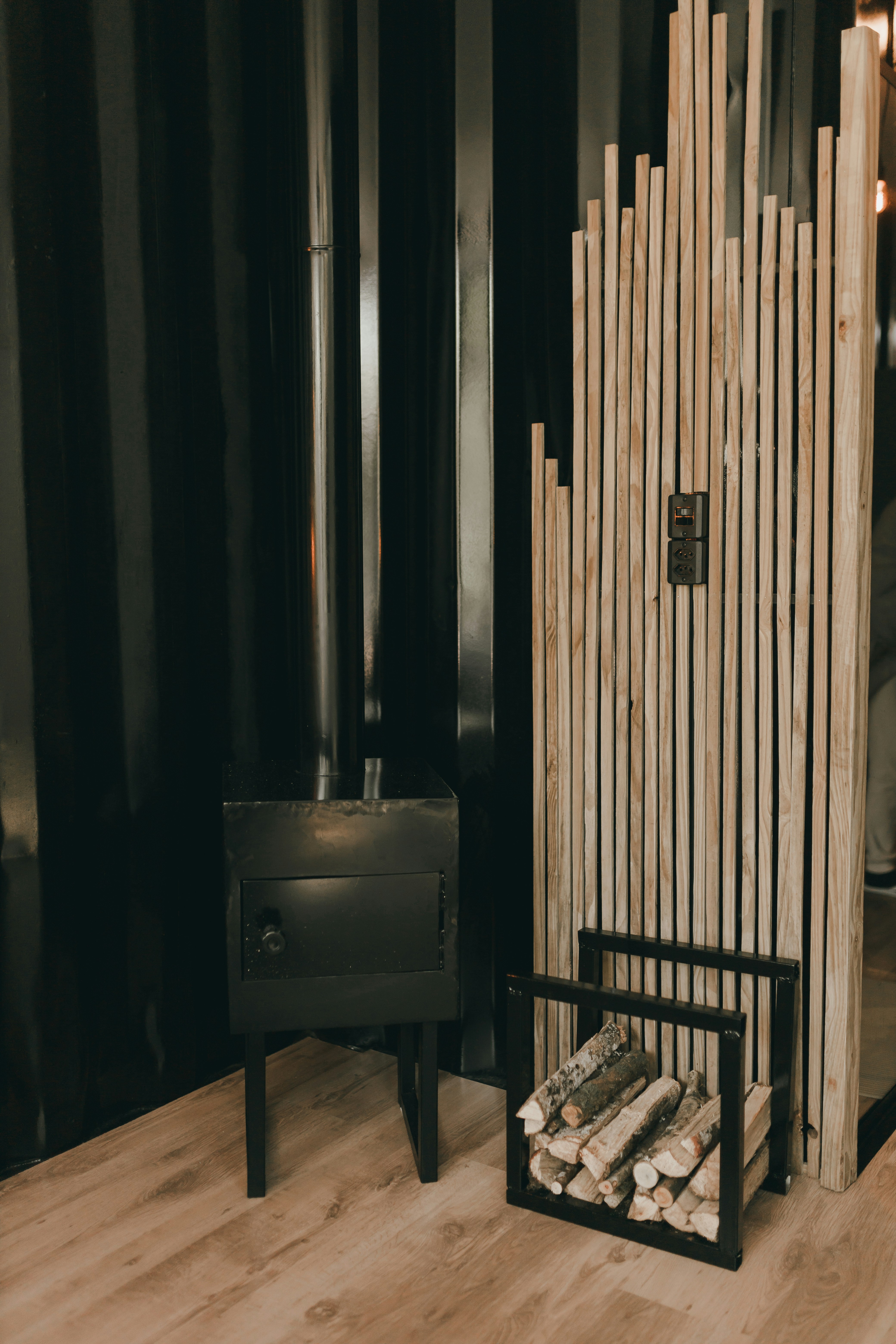 Vertical Warmth: A Cozy Hearth with Log Basket and Slim Stove