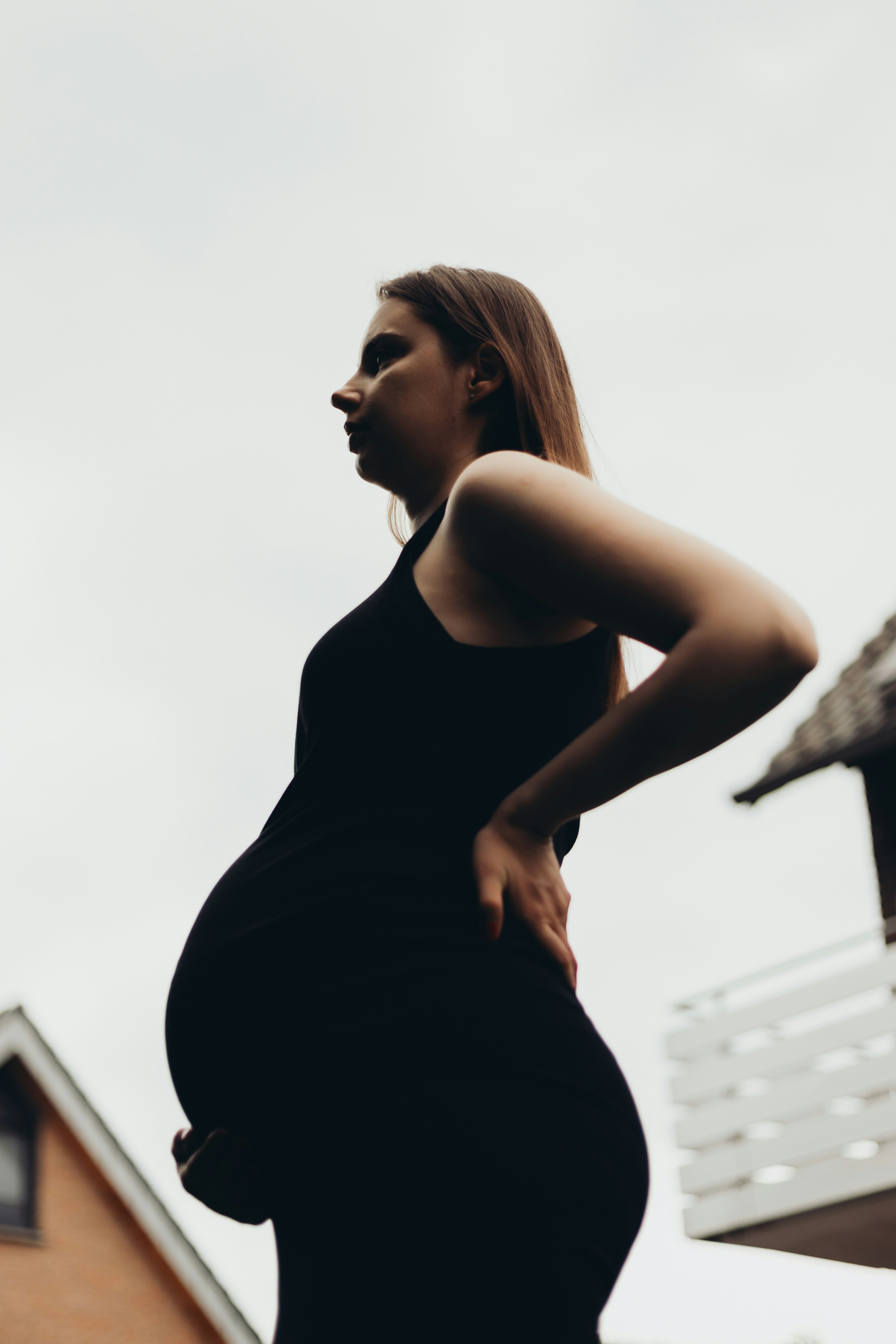 A pregnant woman standing in front of a building photo – Free Woman ...
