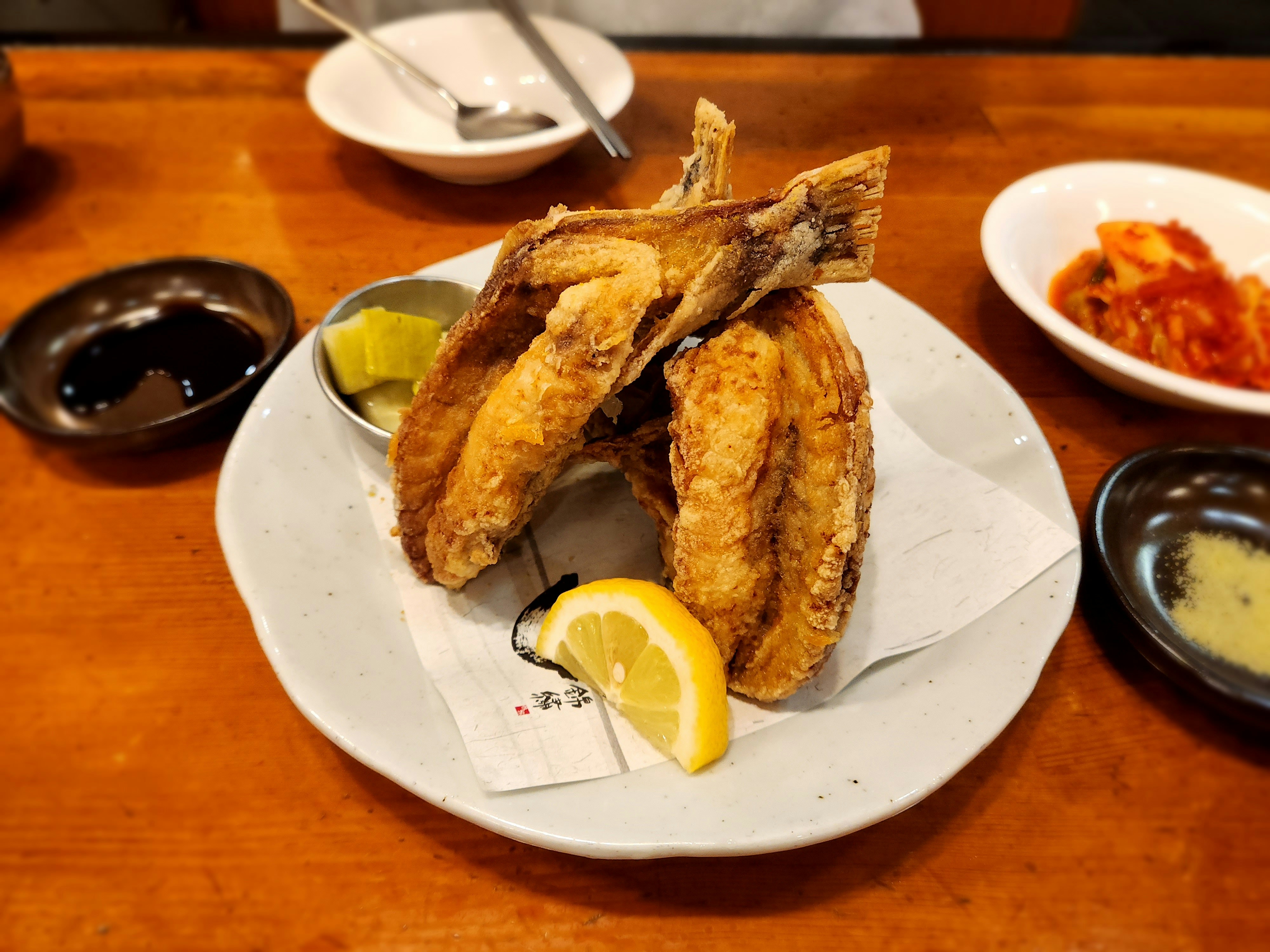 Stacked Crispy Fish: Golden Fillets Crowned with Lemon on a White Plate