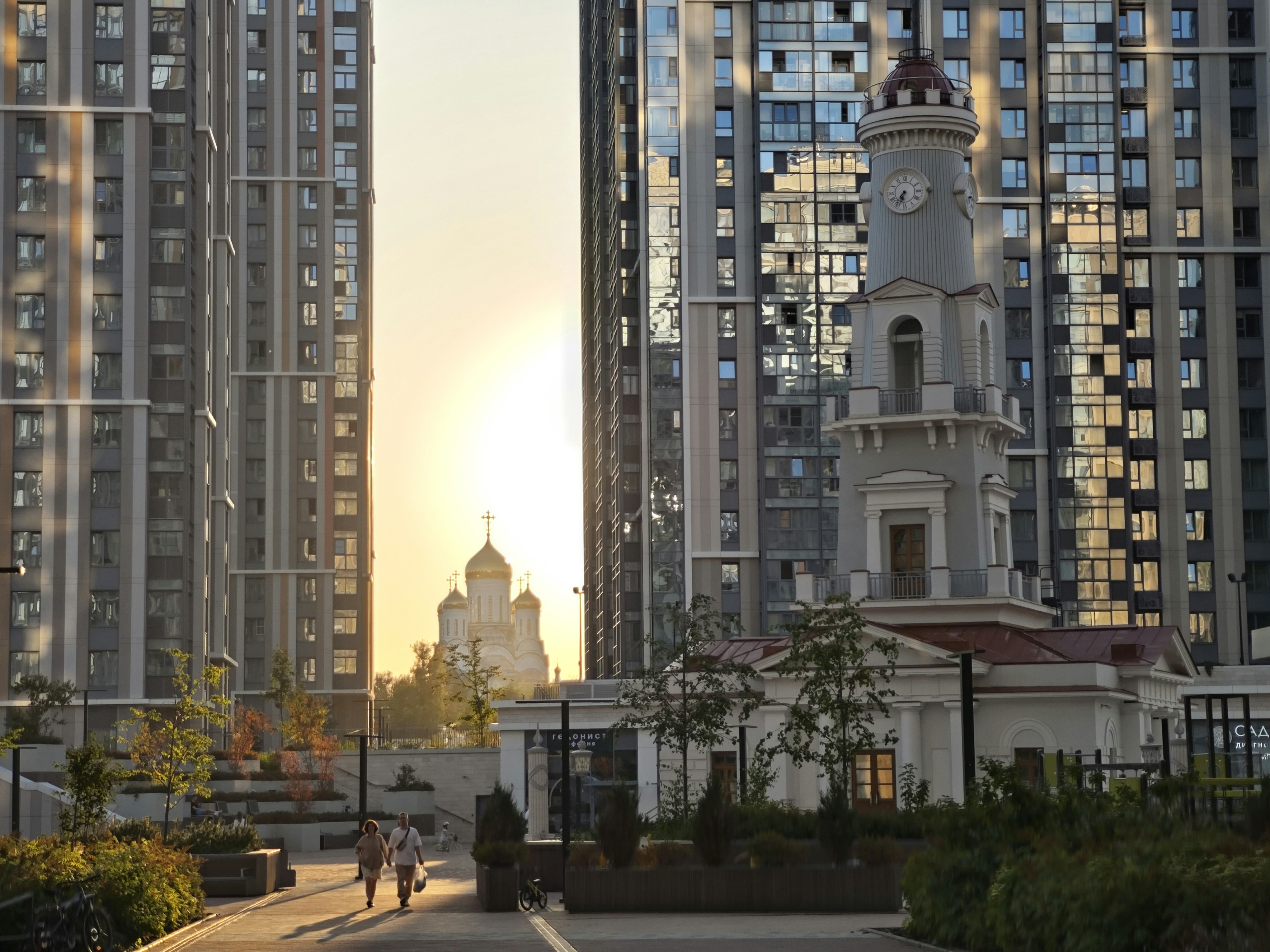 A city street with tall buildings and a clock tower