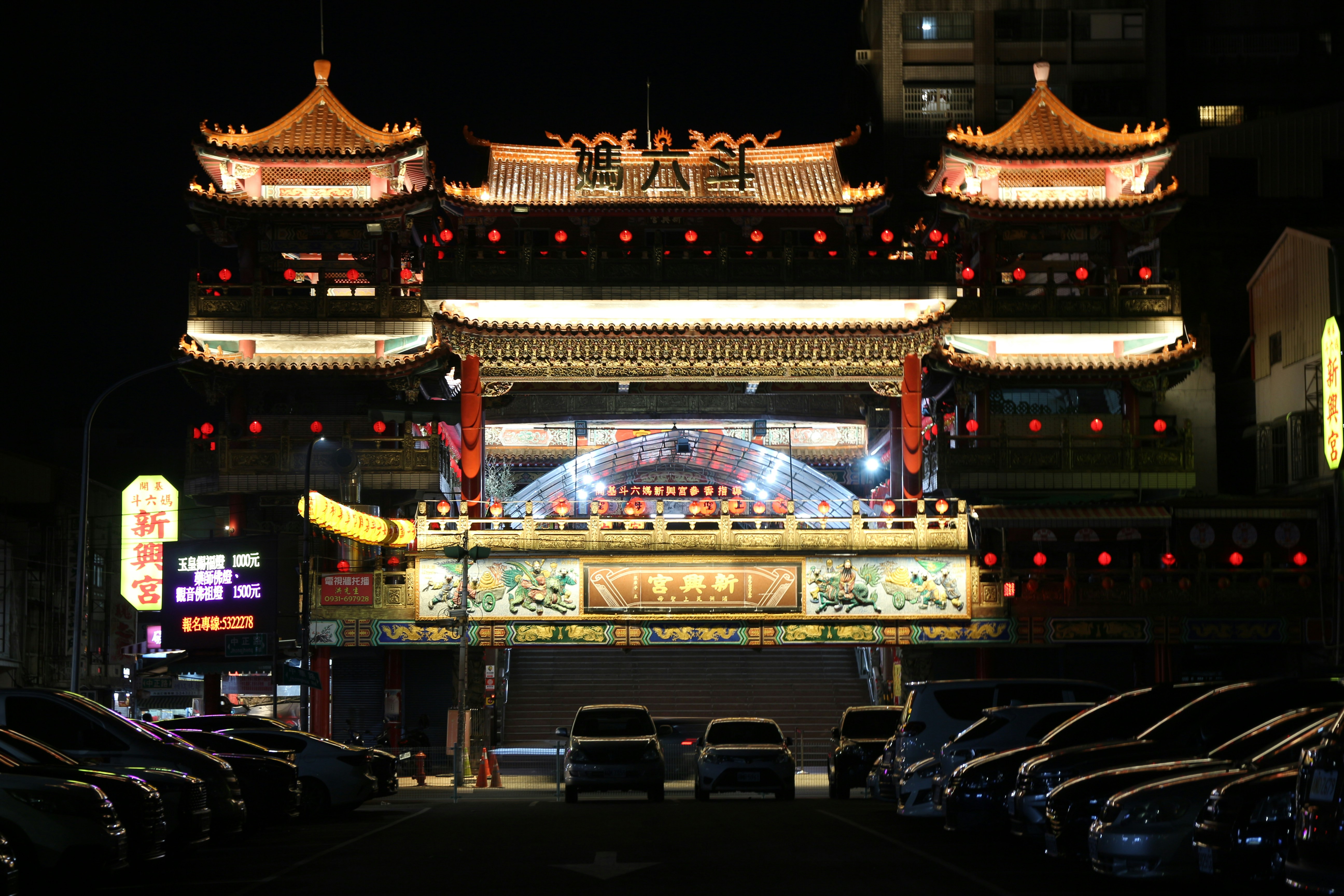 Vibrant temple adorned with lanterns and intricate architecture, standing out against the night sky. The scene captures the essence of cultural celebration.
