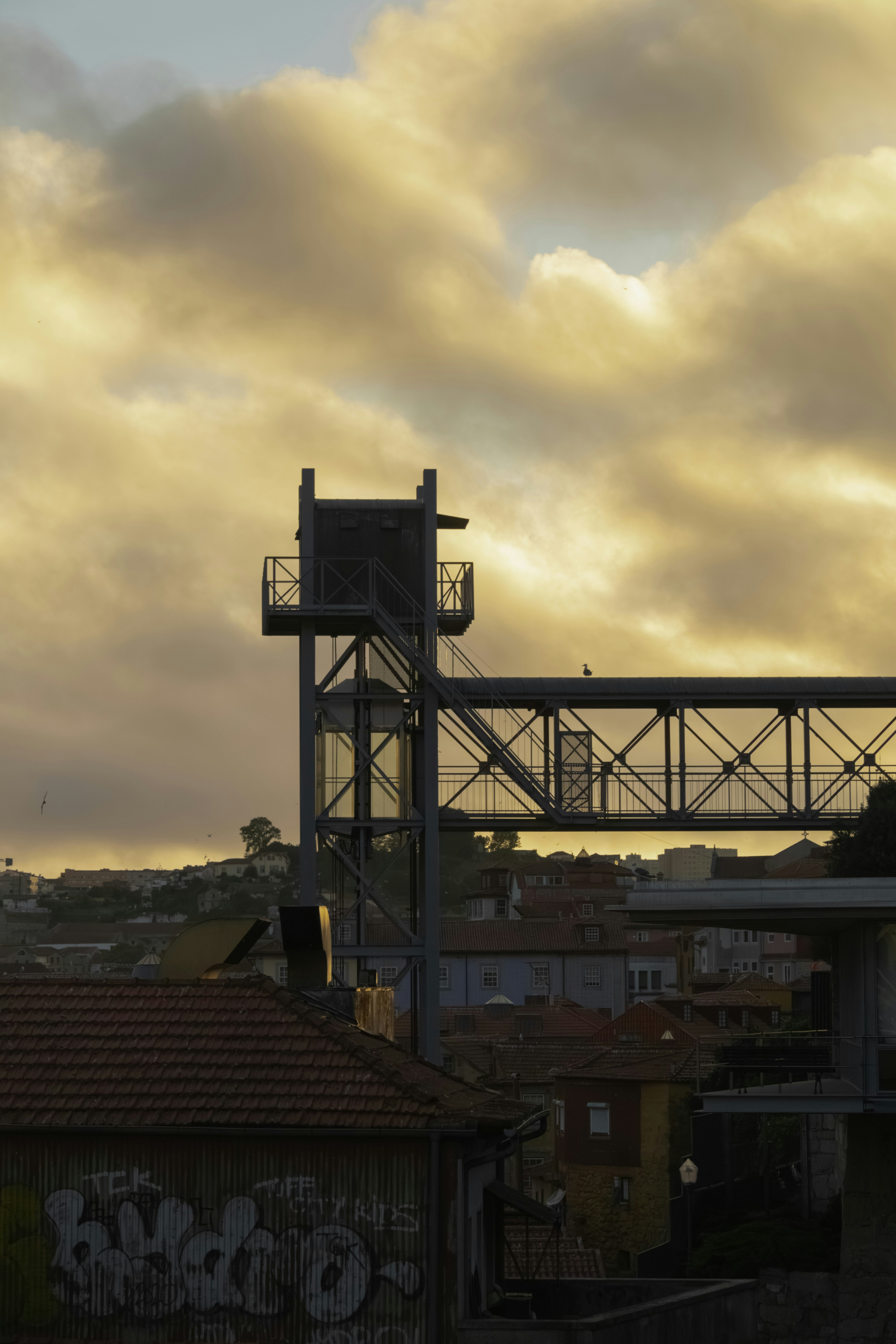 Industrial silhouette at golden hour over a quiet cityscape