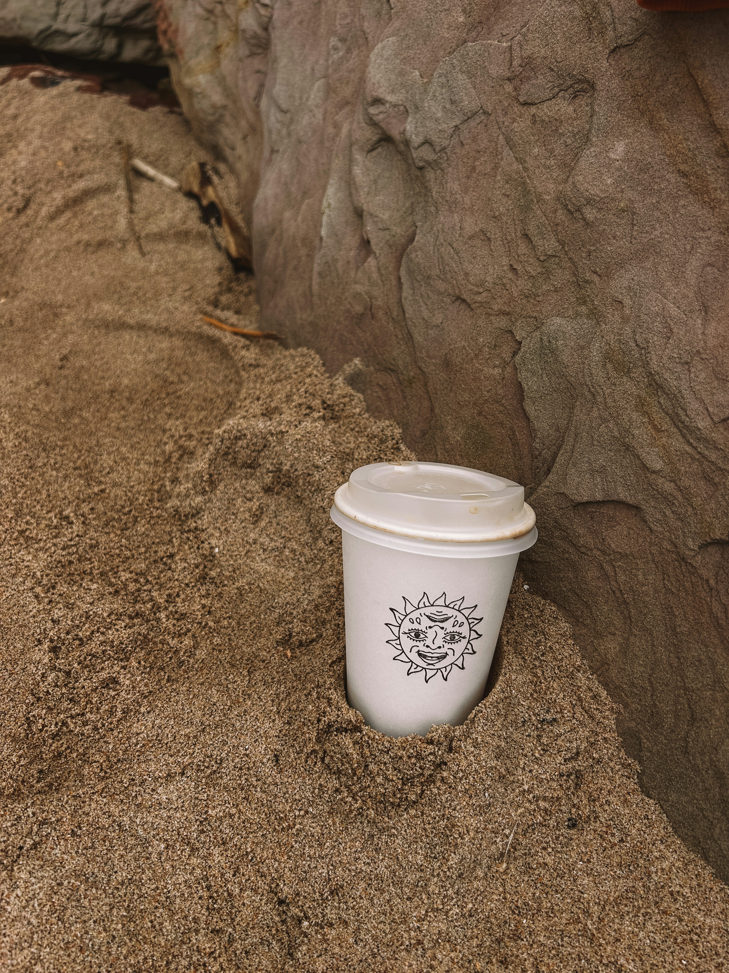 A cup of coffee sitting in the sandToa Heftiba