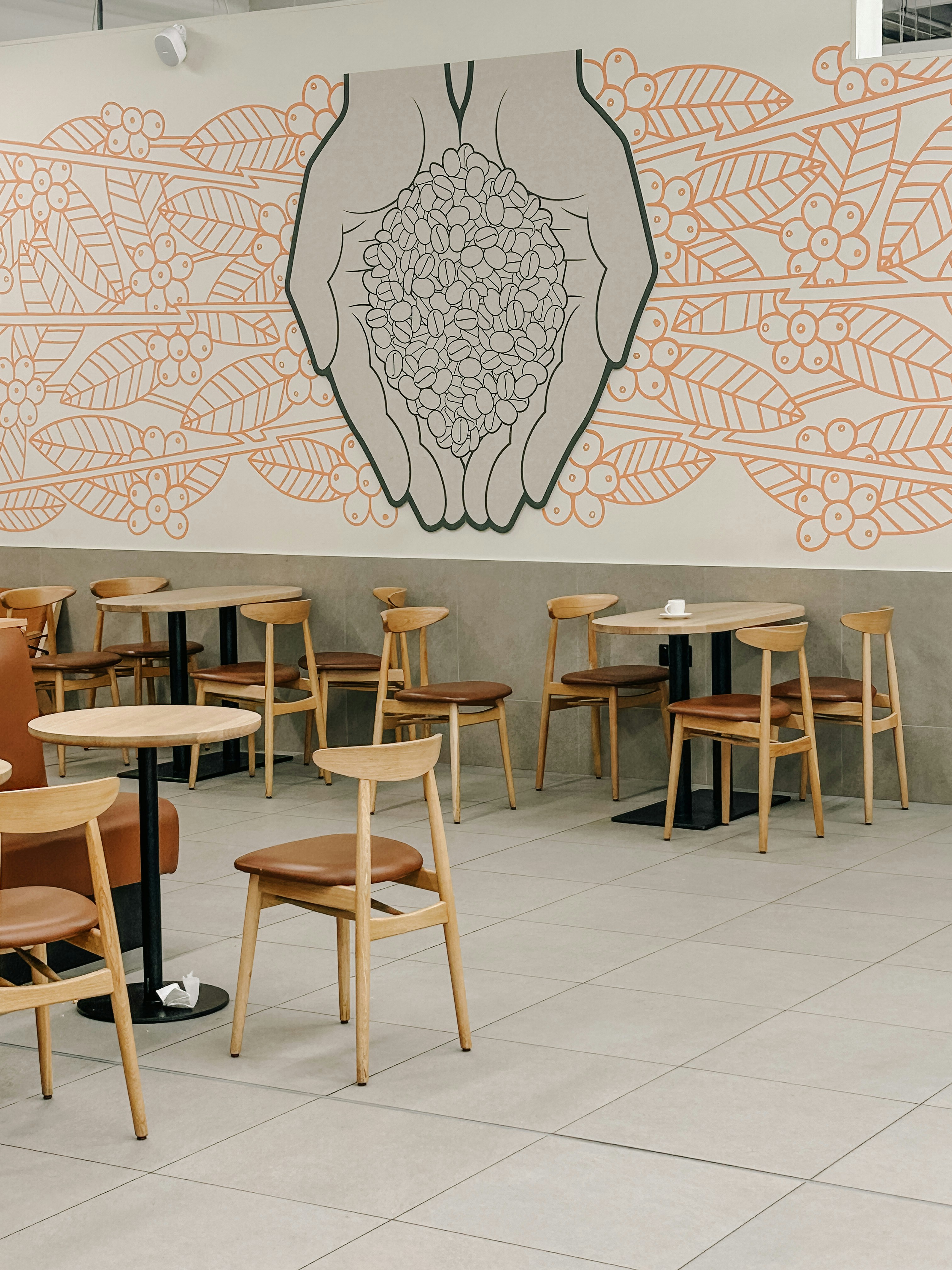 A restaurant with tables and chairs and a large mural on the wall photo ...