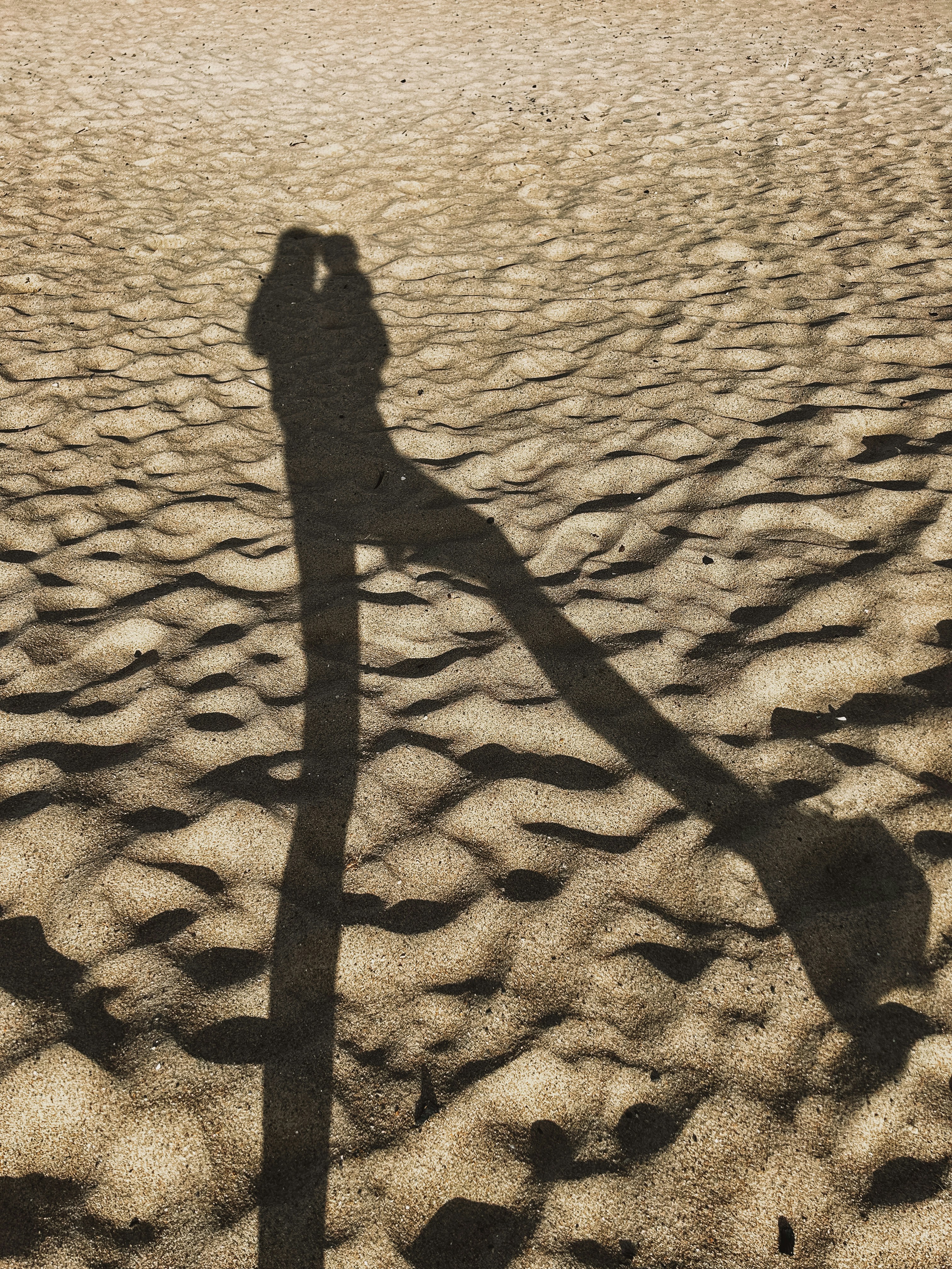 A shadow of a person standing on a beach