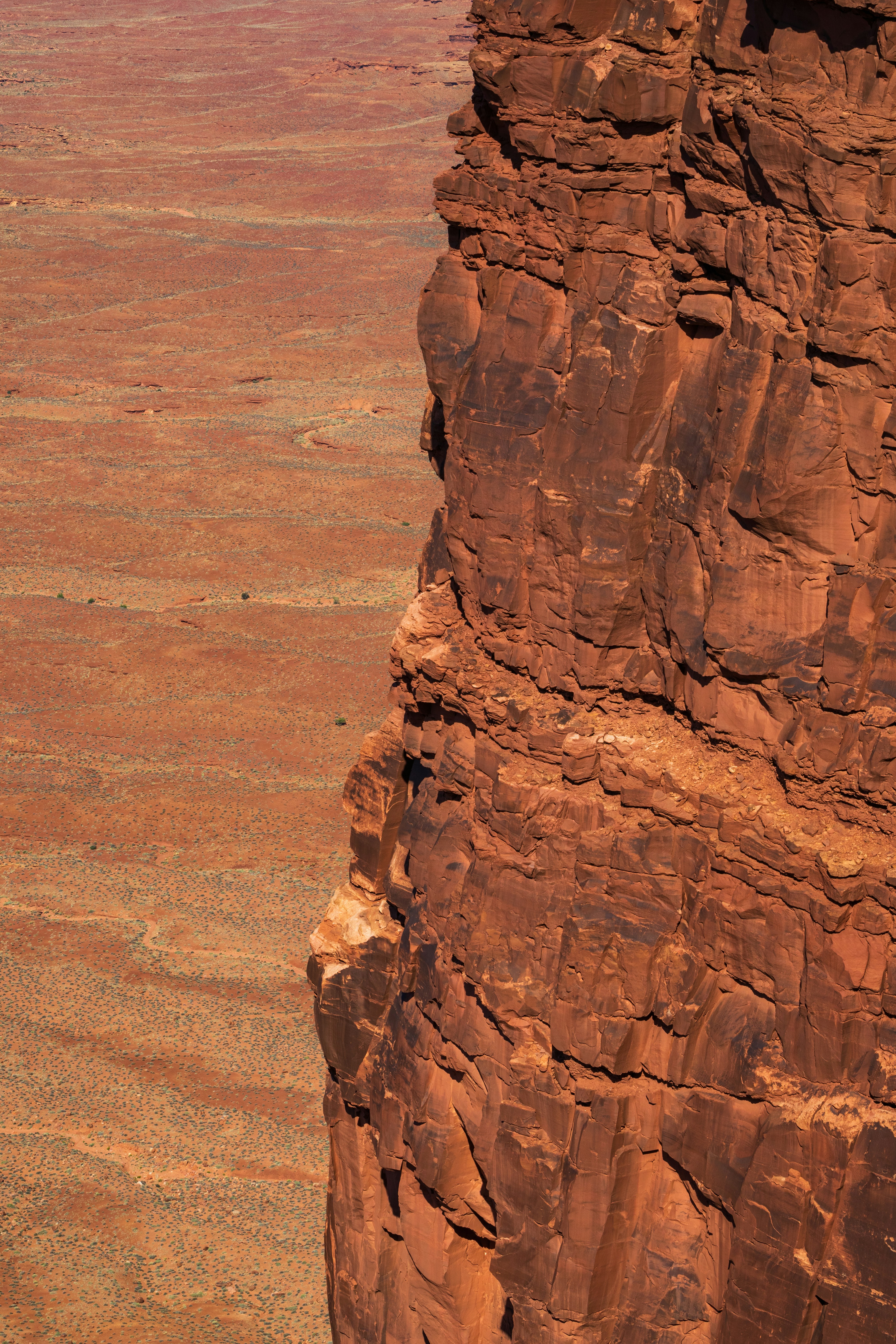 Crimson Cliff Edge Over a Desert Plain