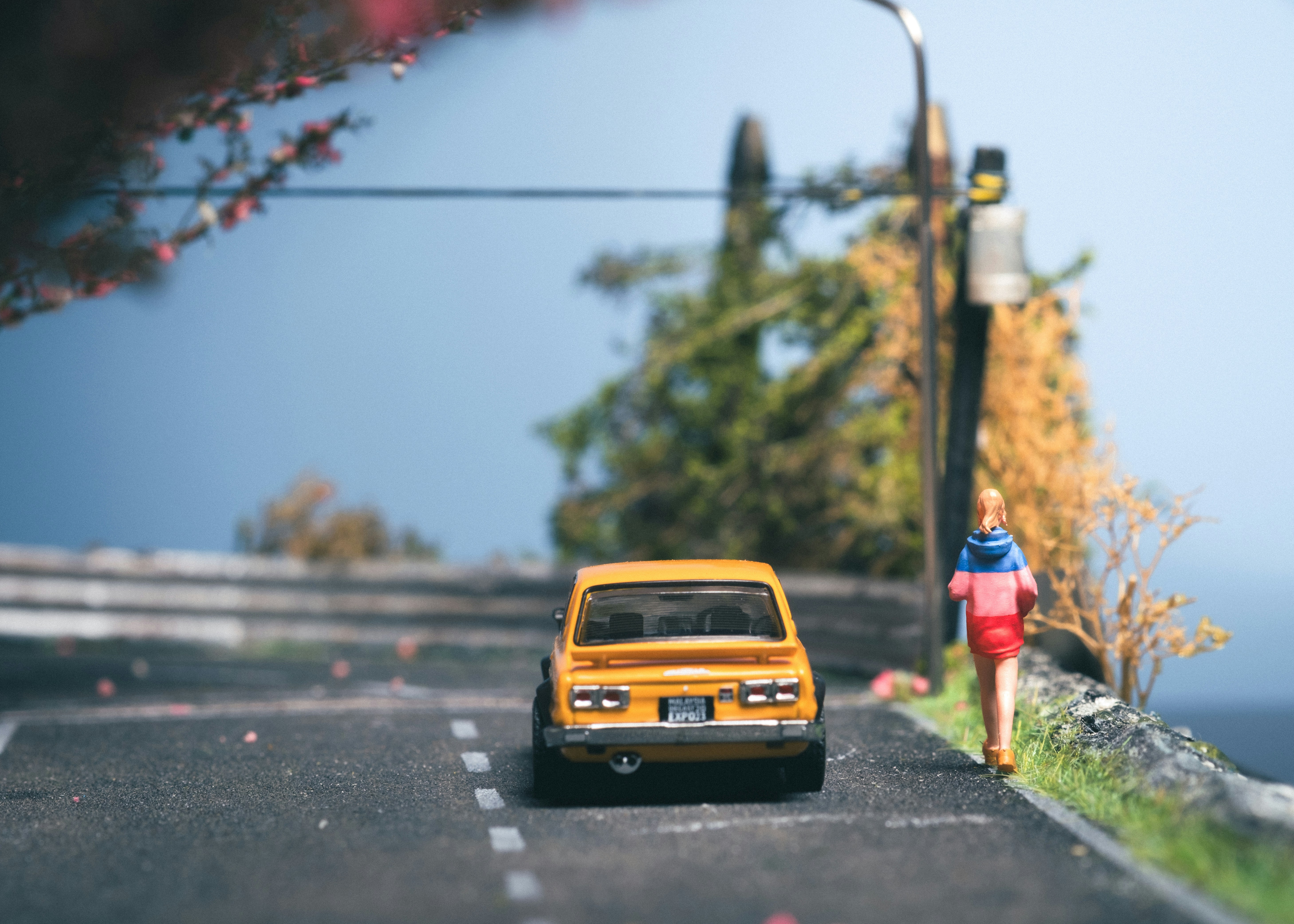 Miniature Roadside Moment: A Tiny Car Cools Off by a Cliffside Walk