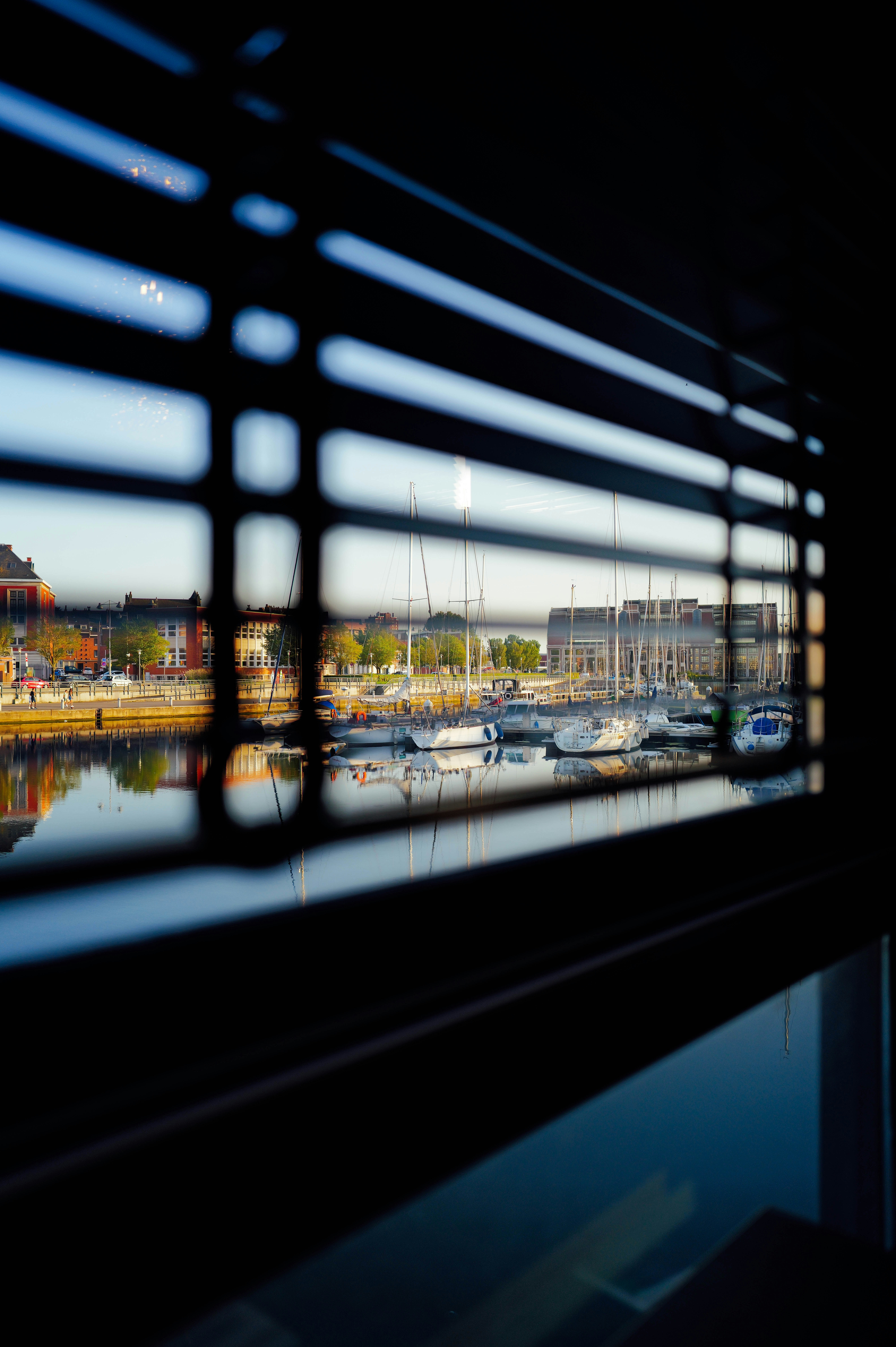 A view of a harbor through a window photo – Free Water Image on Unsplash