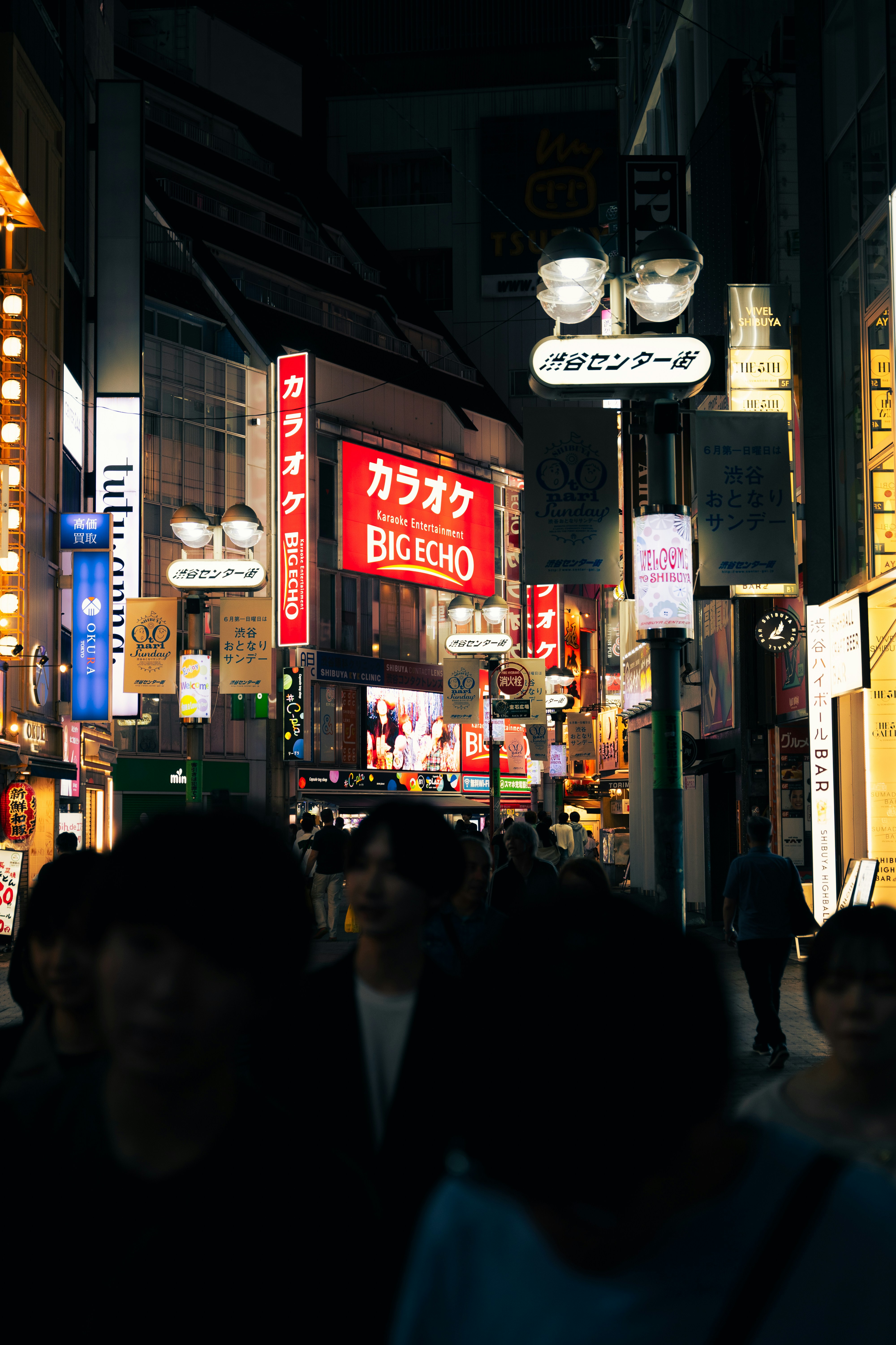 A crowded city street at night with neon signs photo – Free Street ...