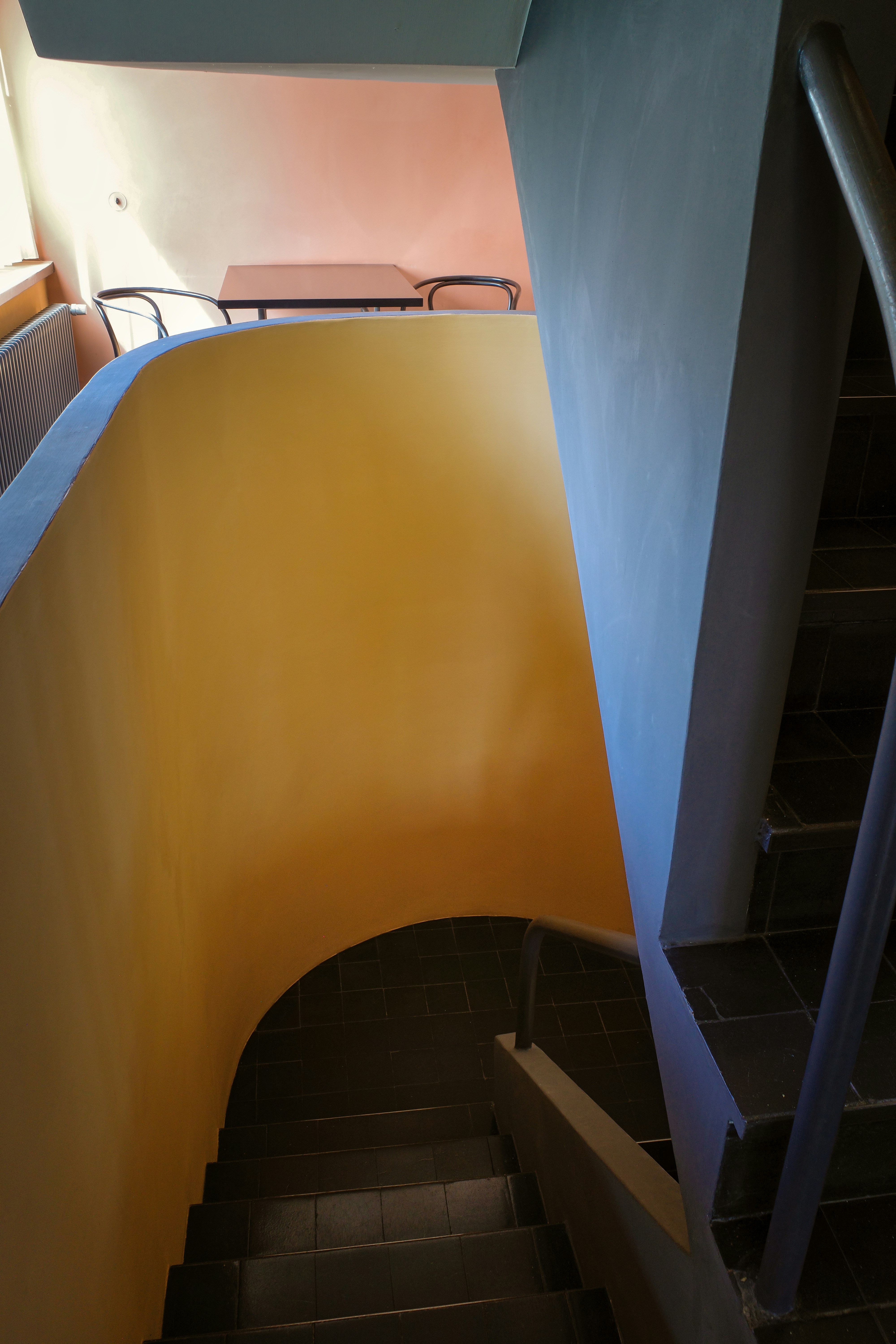 Archway of Color: A Sunlit Stairwell Curve