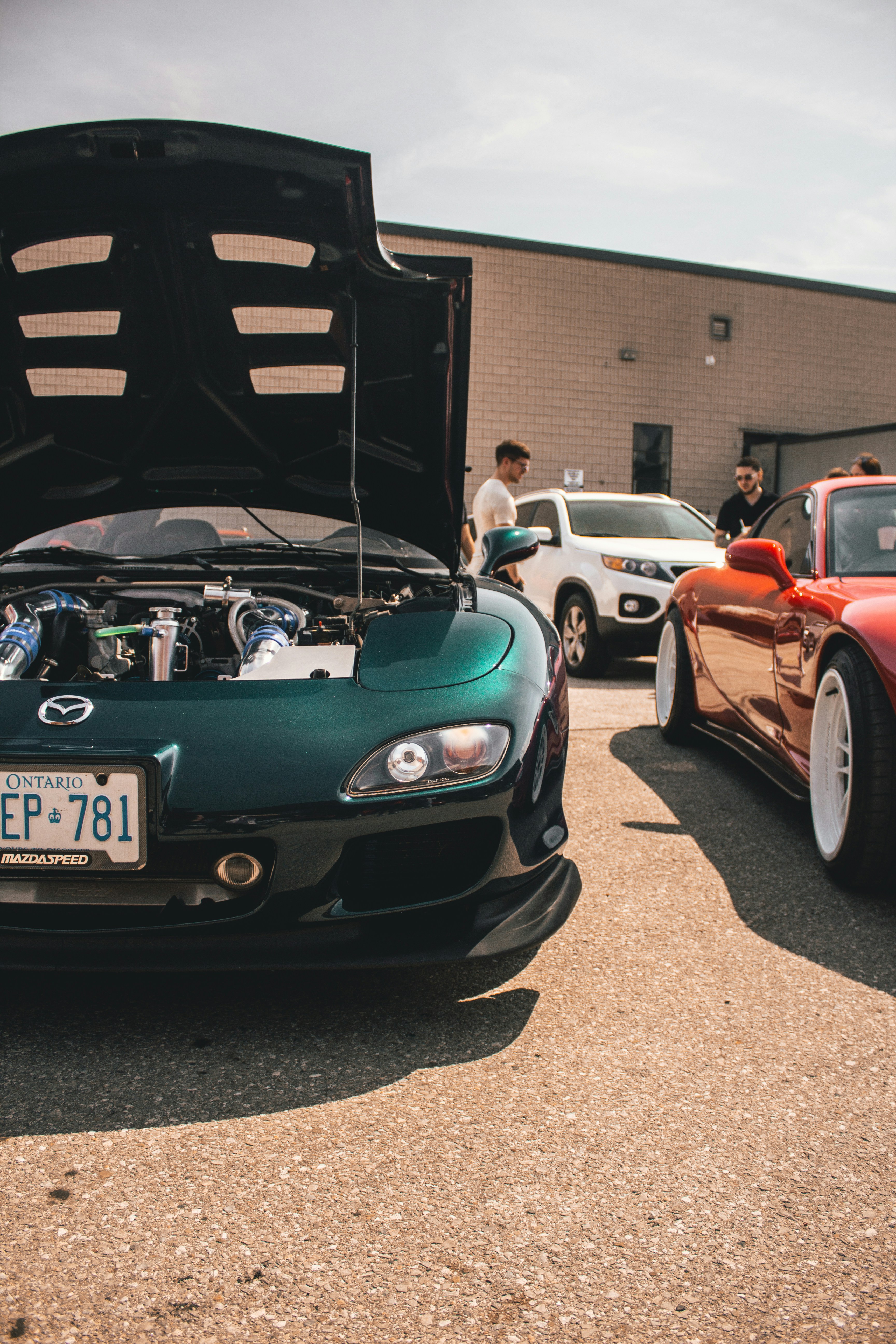 Green Mazda at Car Meet: Hood Open, Engines on Display