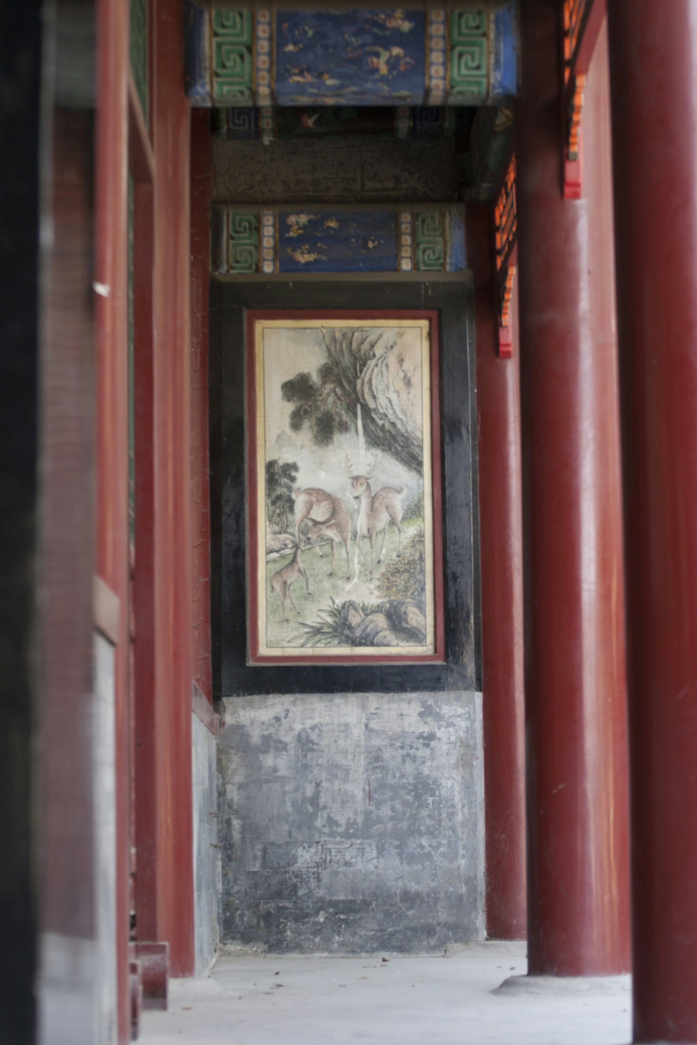 Crimson Columns Framing a Deer Scene in a Quiet Corridor
