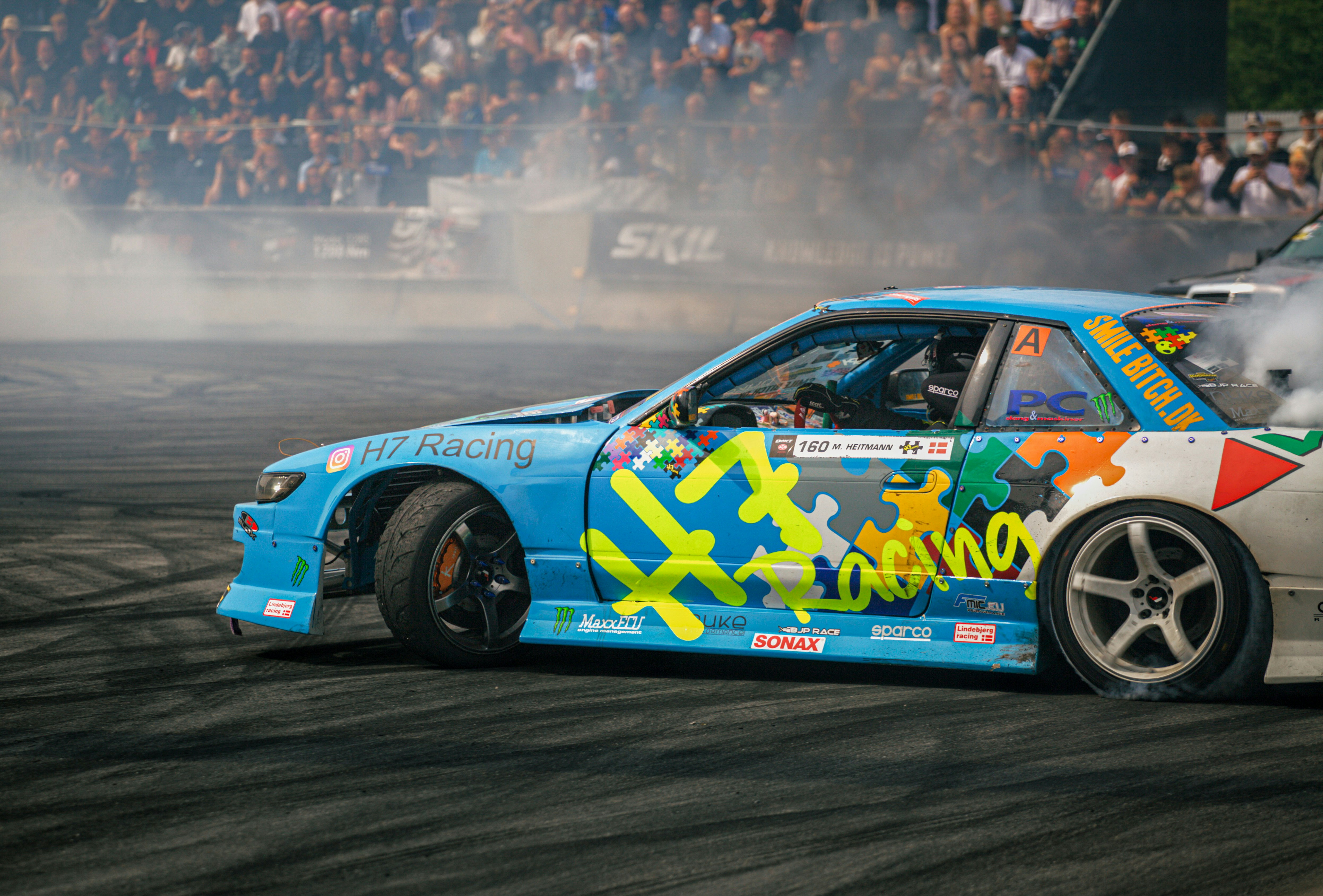 A blue car with numbers painted on it driving around a track photo ...