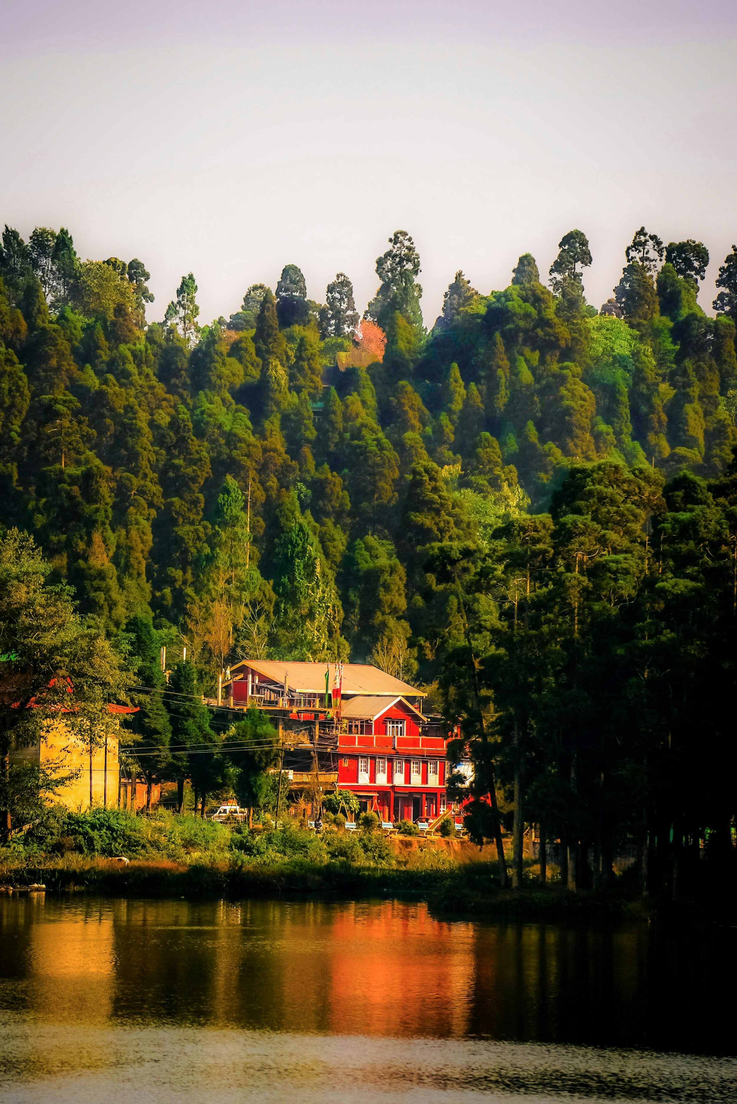 A red house sitting on top of a lush green hillside photo – Free Mirik ...
