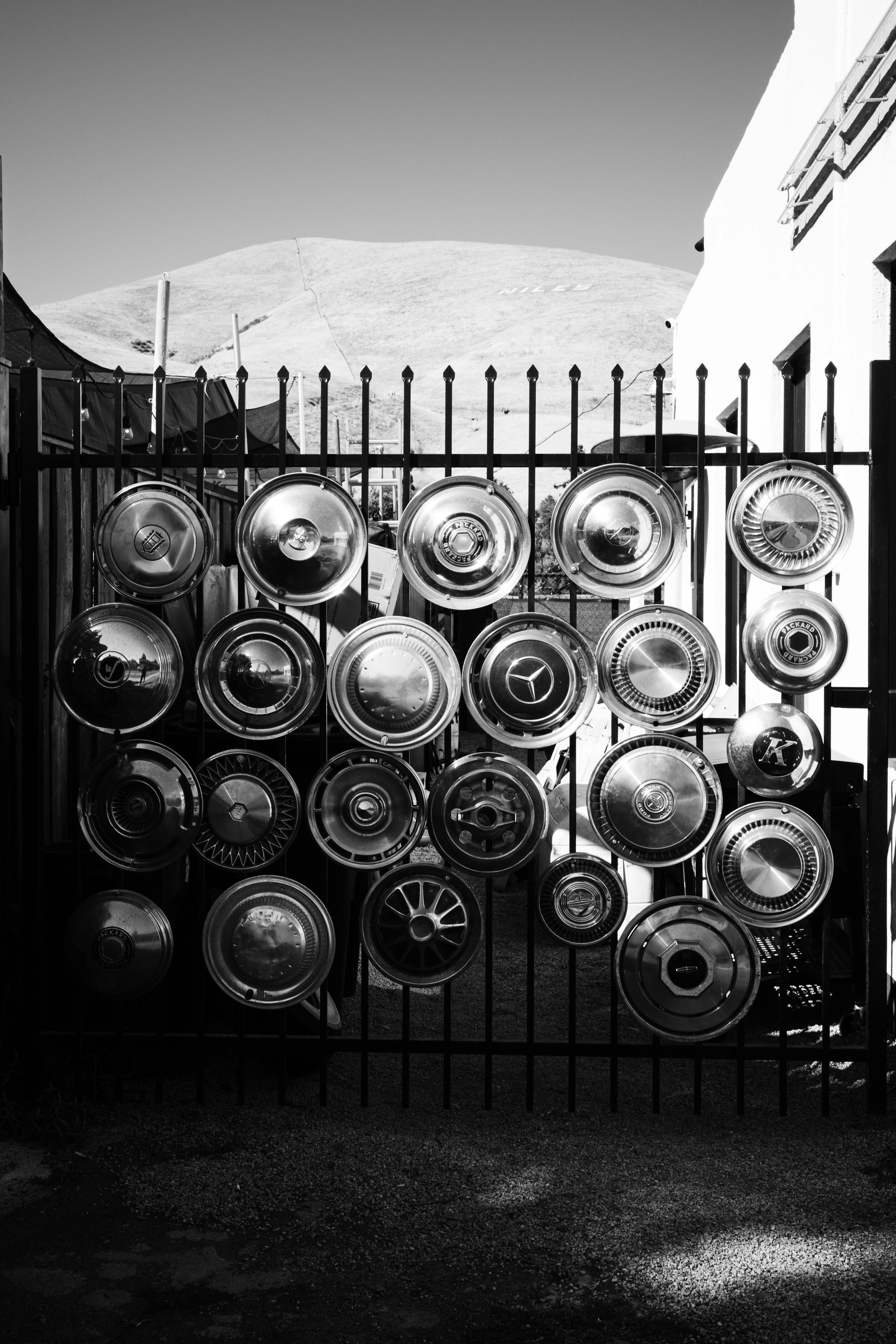Hubcap Mosaic on a Fence: Chrome Orbits in Monochrome