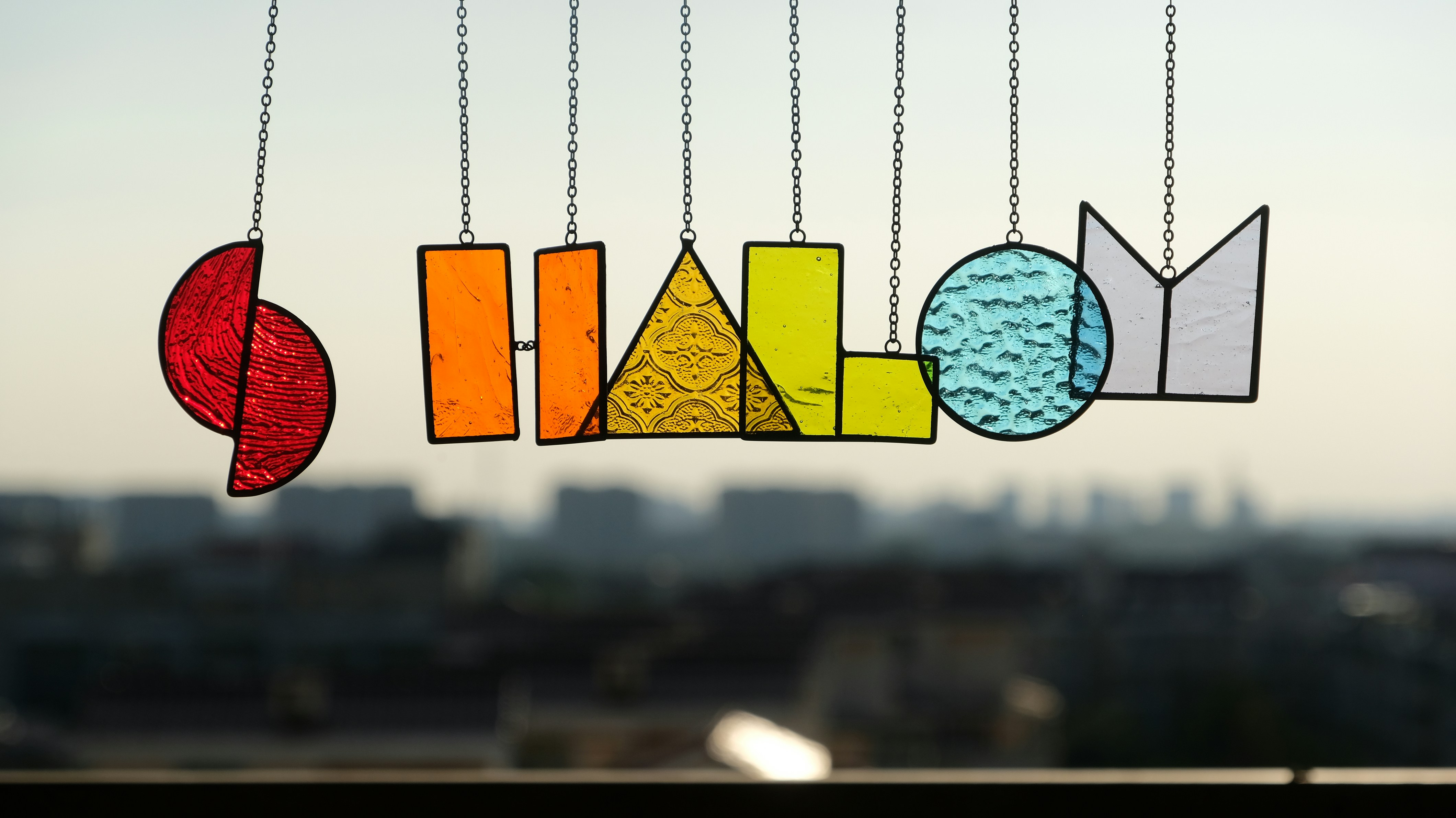 A picture of a window with a string of colorful objects hanging from it ...