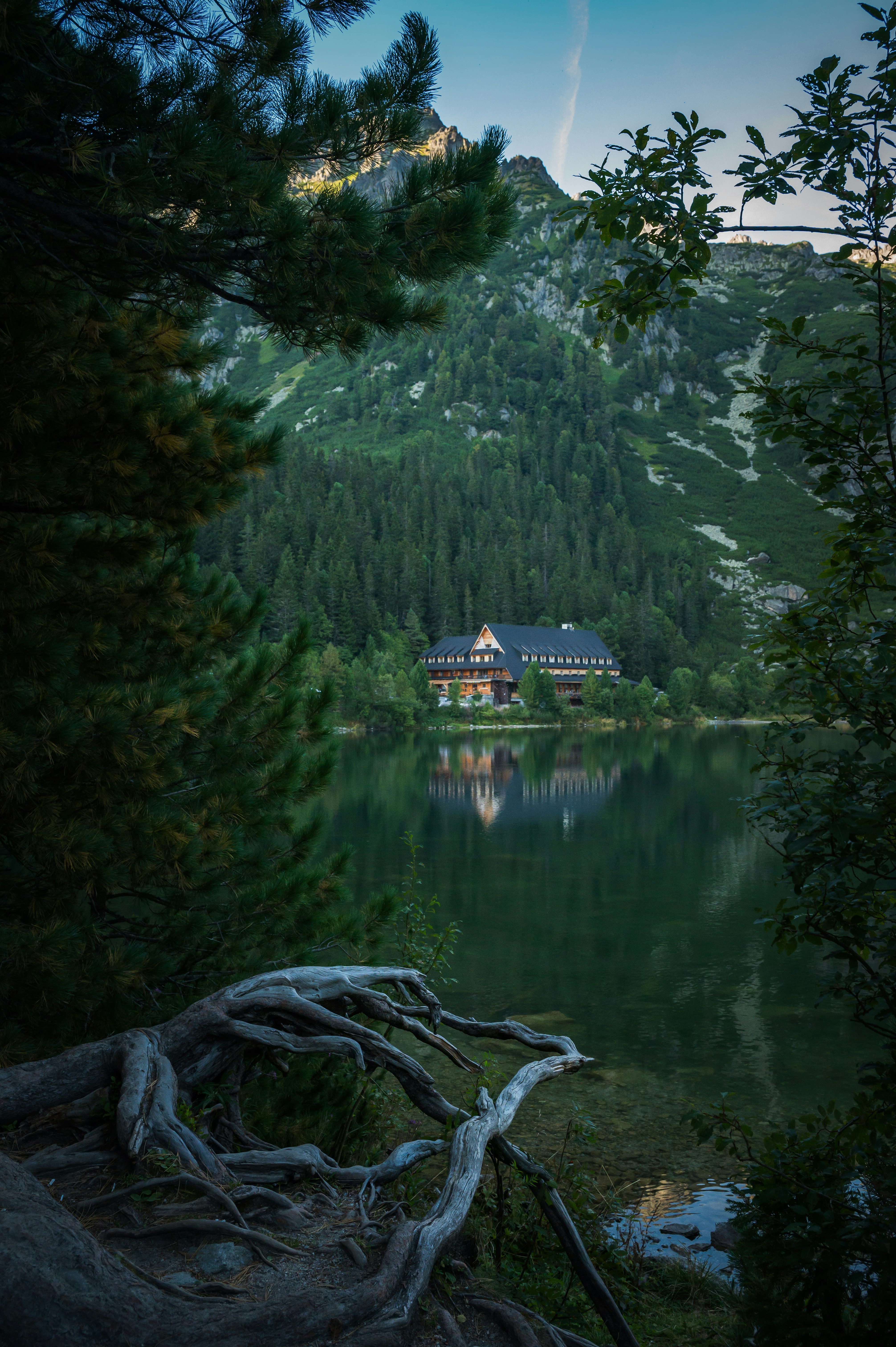 Alpine Lodge on a Quiet Lake Surrounded by Pines and Rugged Peaks