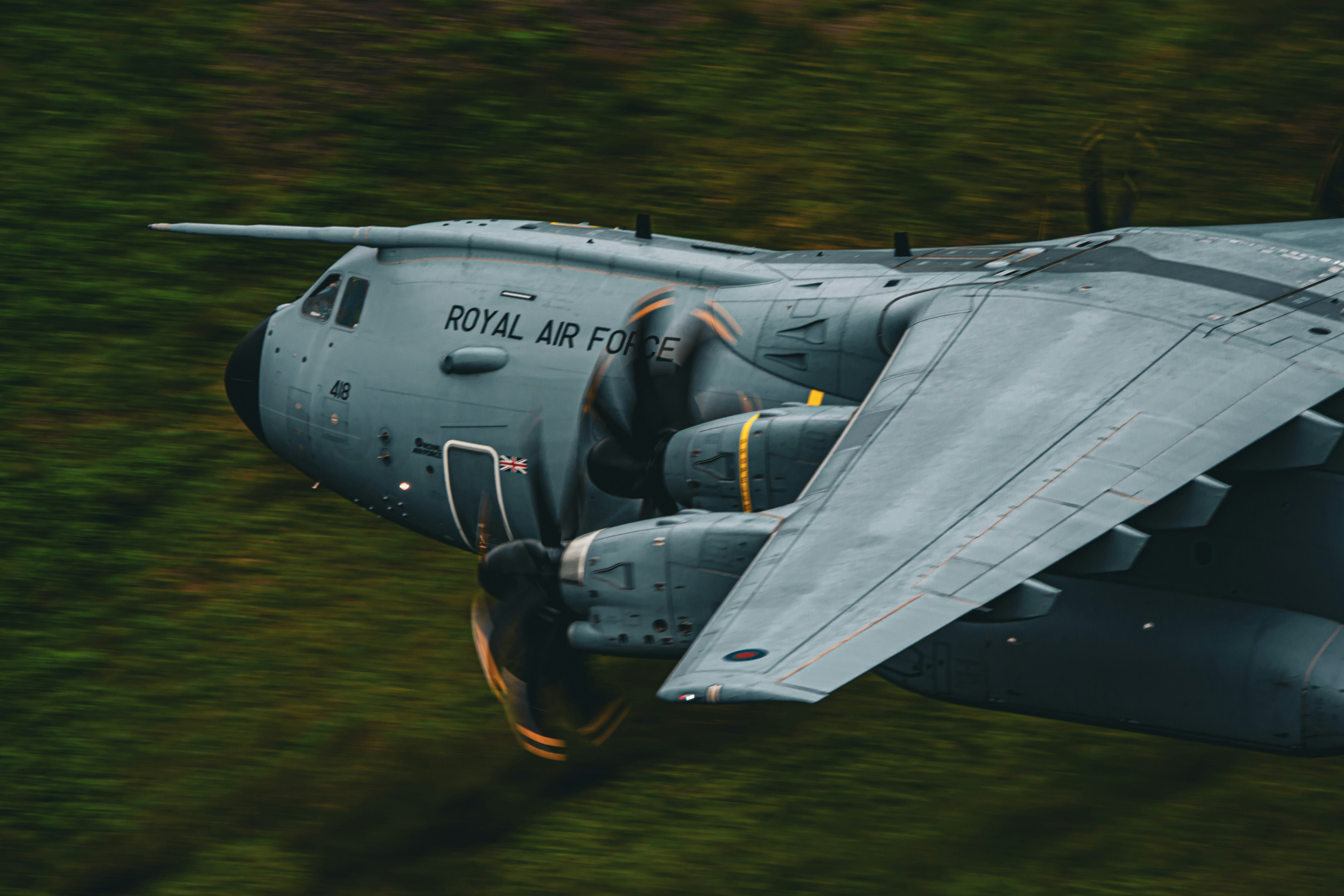 A fighter jet flying over a lush green field photo – Free Airplane ...