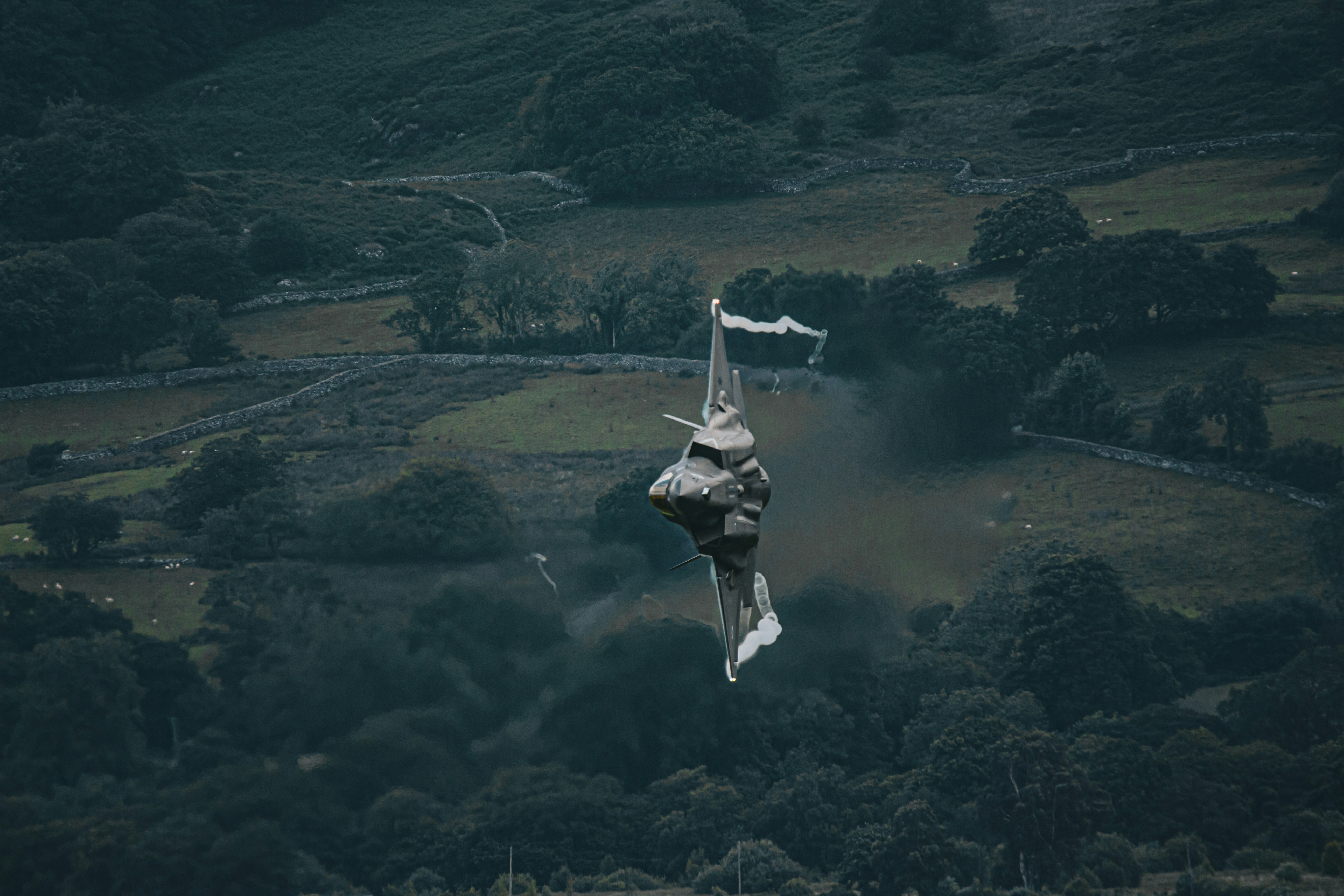 Midair Silhouette: A Phantom Jet Slices Through Misty Hills