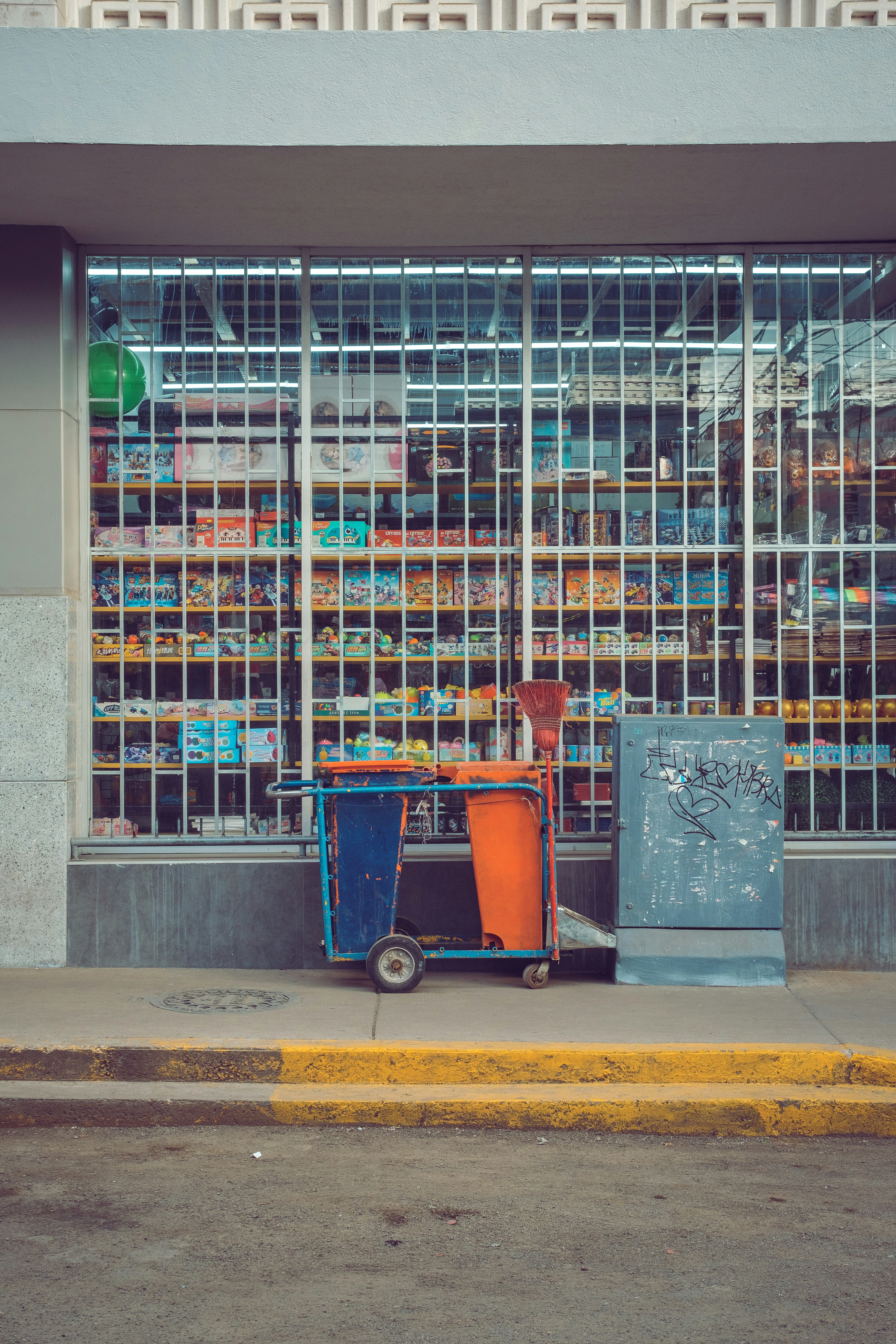 Pastel Grids and a City Cart: A Quiet Storefront Portrait